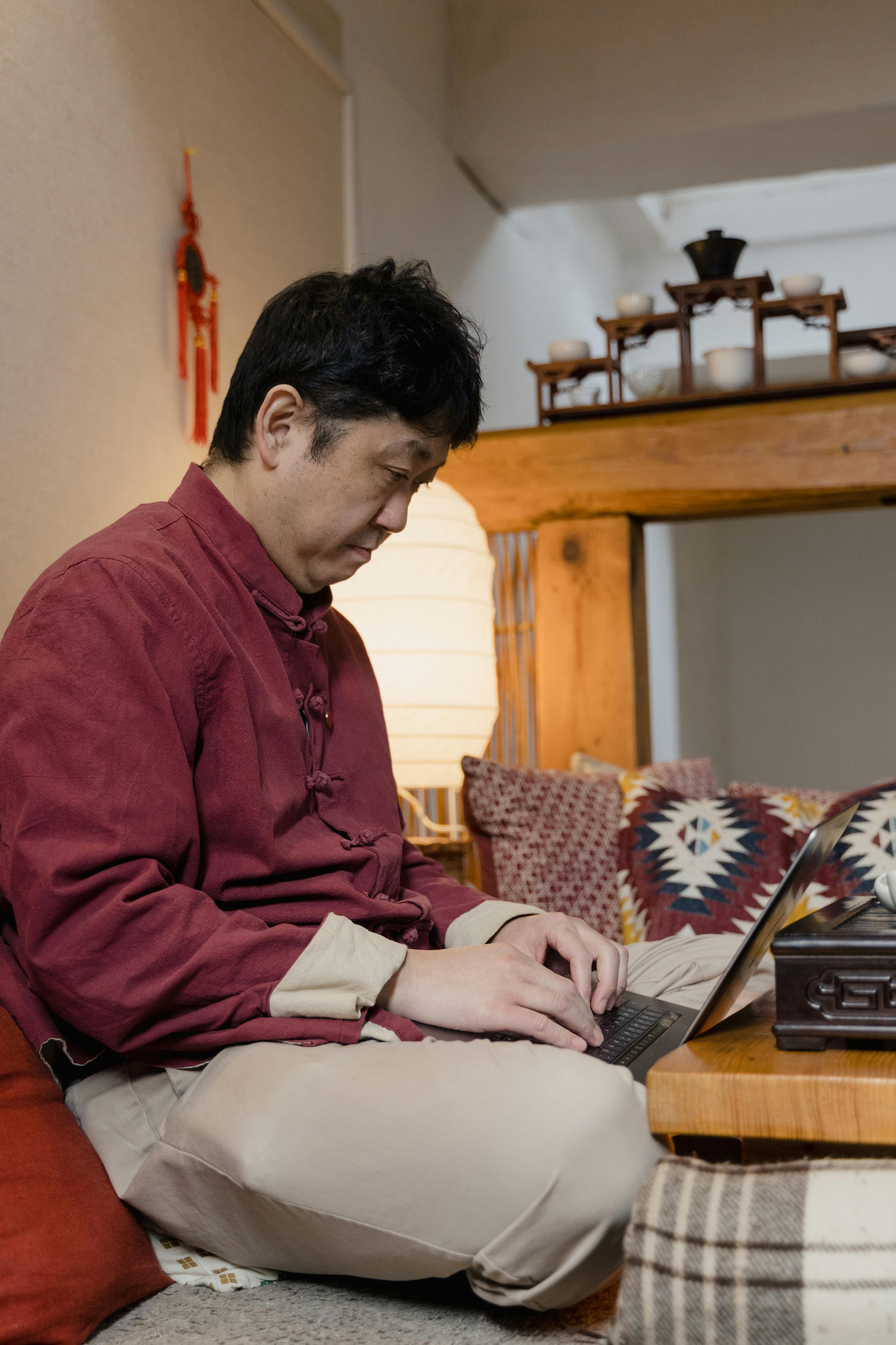Man in Maroon Long Sleeves Using a Laptop · Free Stock Photo