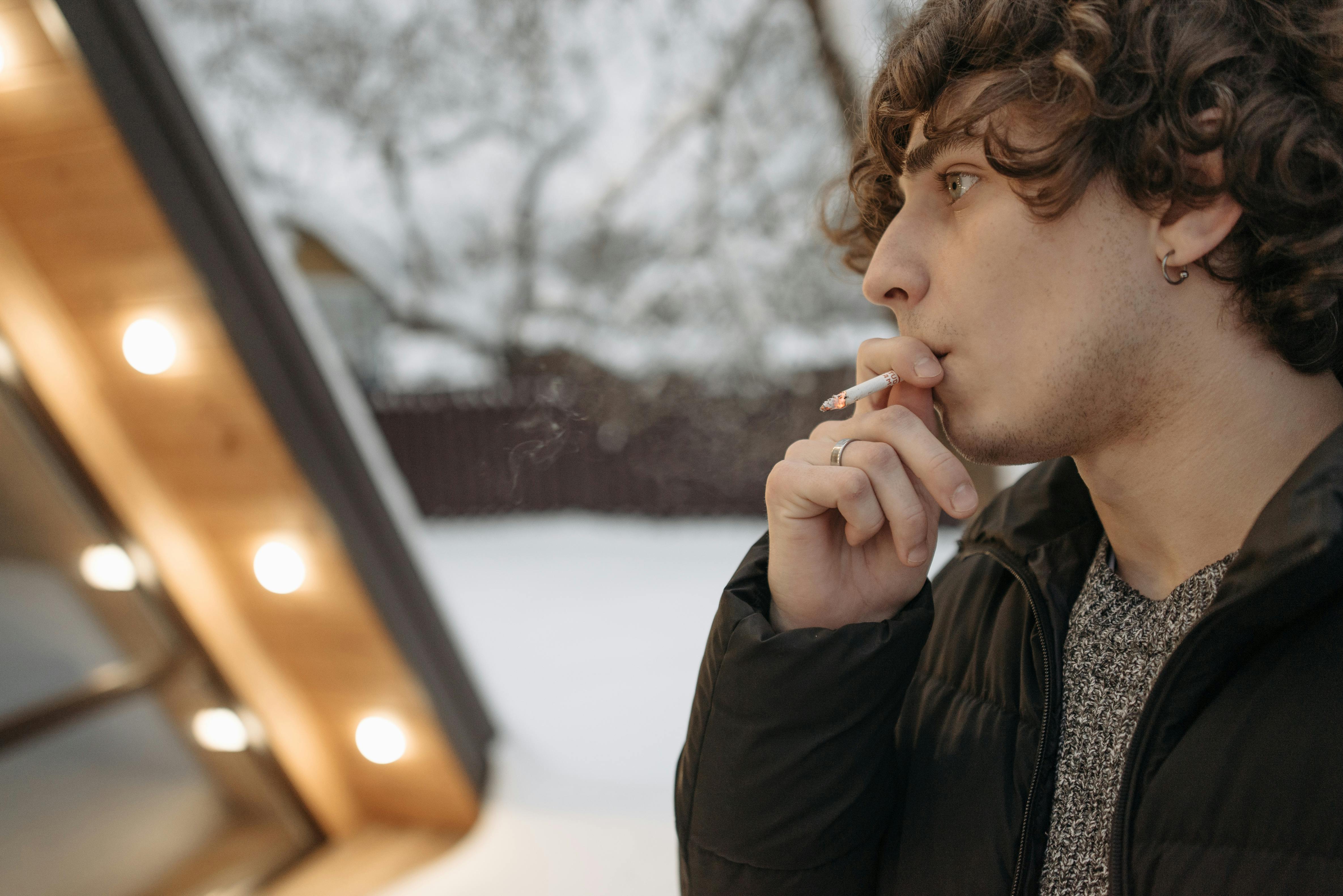 A Man in Black Winter Jacket Smoking Cigarette · Free Stock Photo