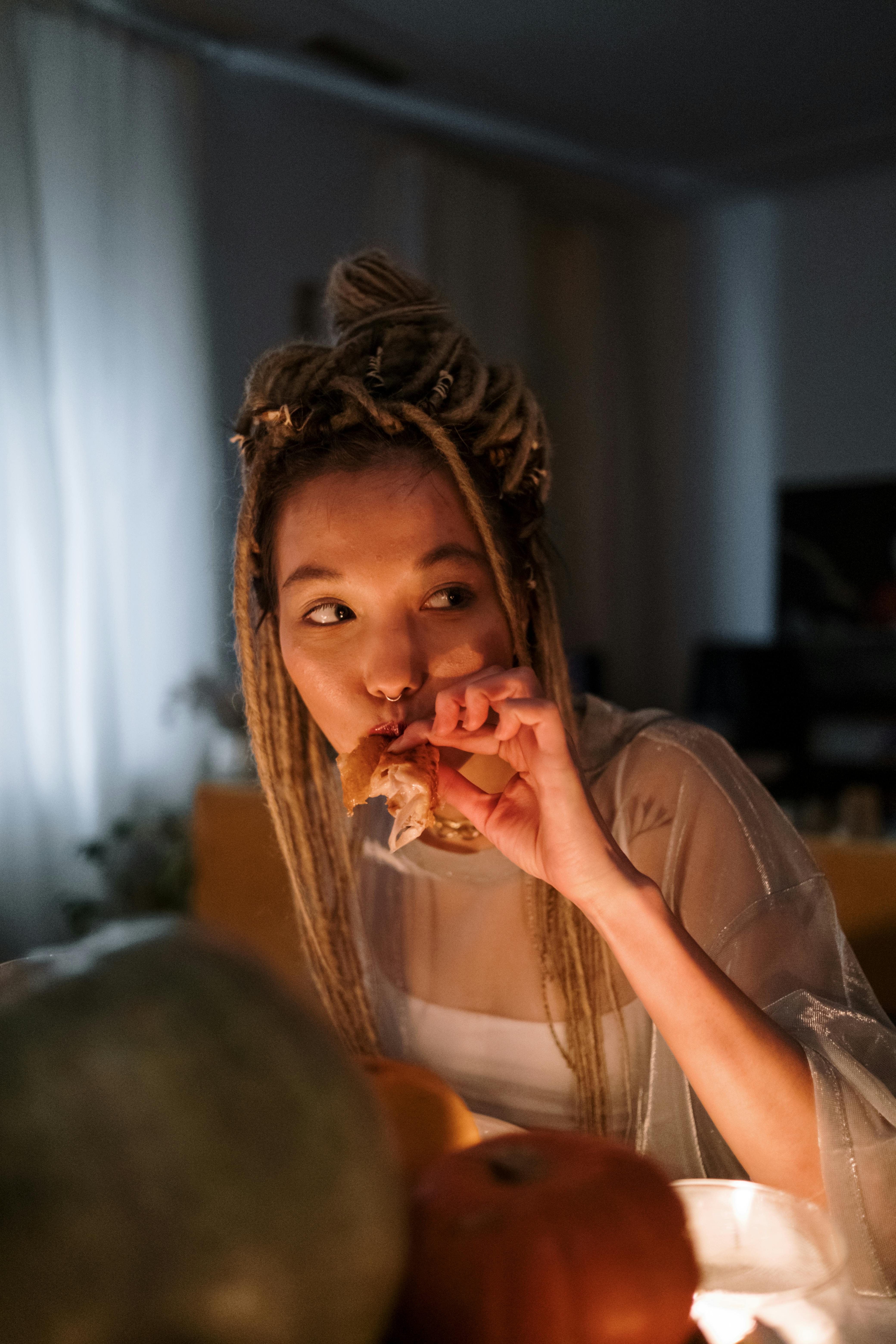 Photo of a Woman with Dreadlocks Eating while Looking Sideways · Free ...