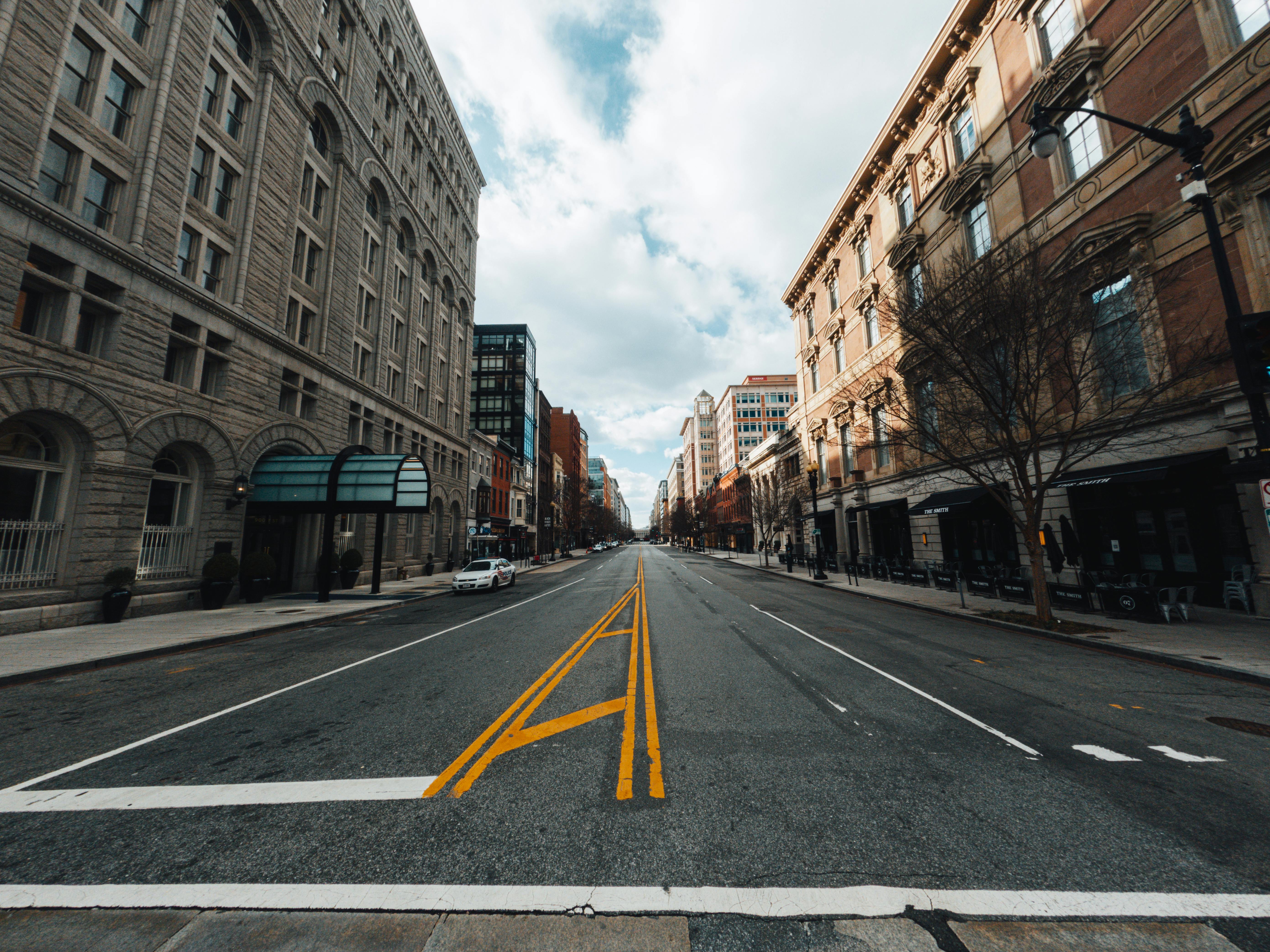 Empty road between old masonry house facades in city · Free Stock Photo