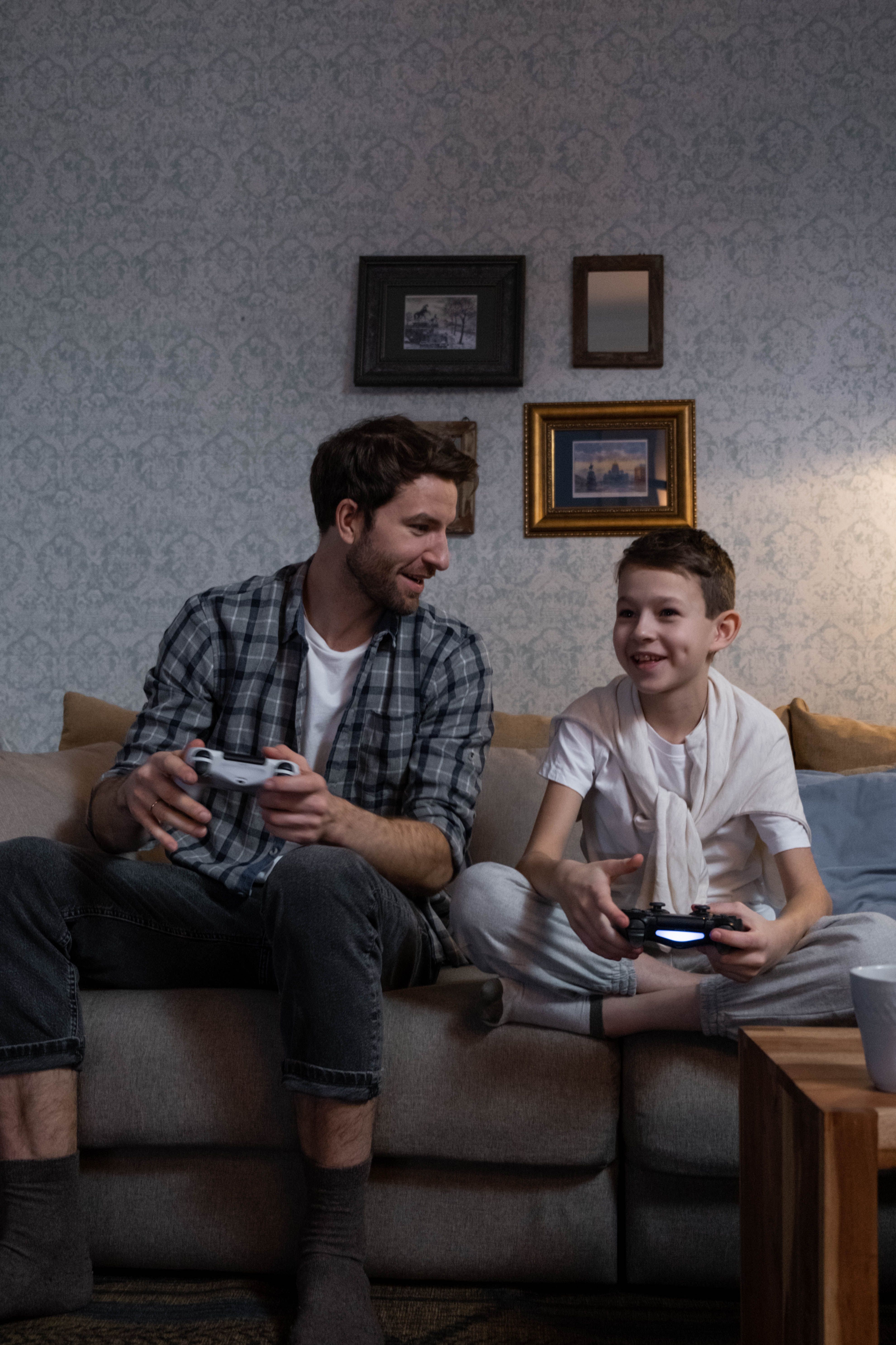 A Man and a Kid Playing Video Games while Sitting on the Sofa · Free ...