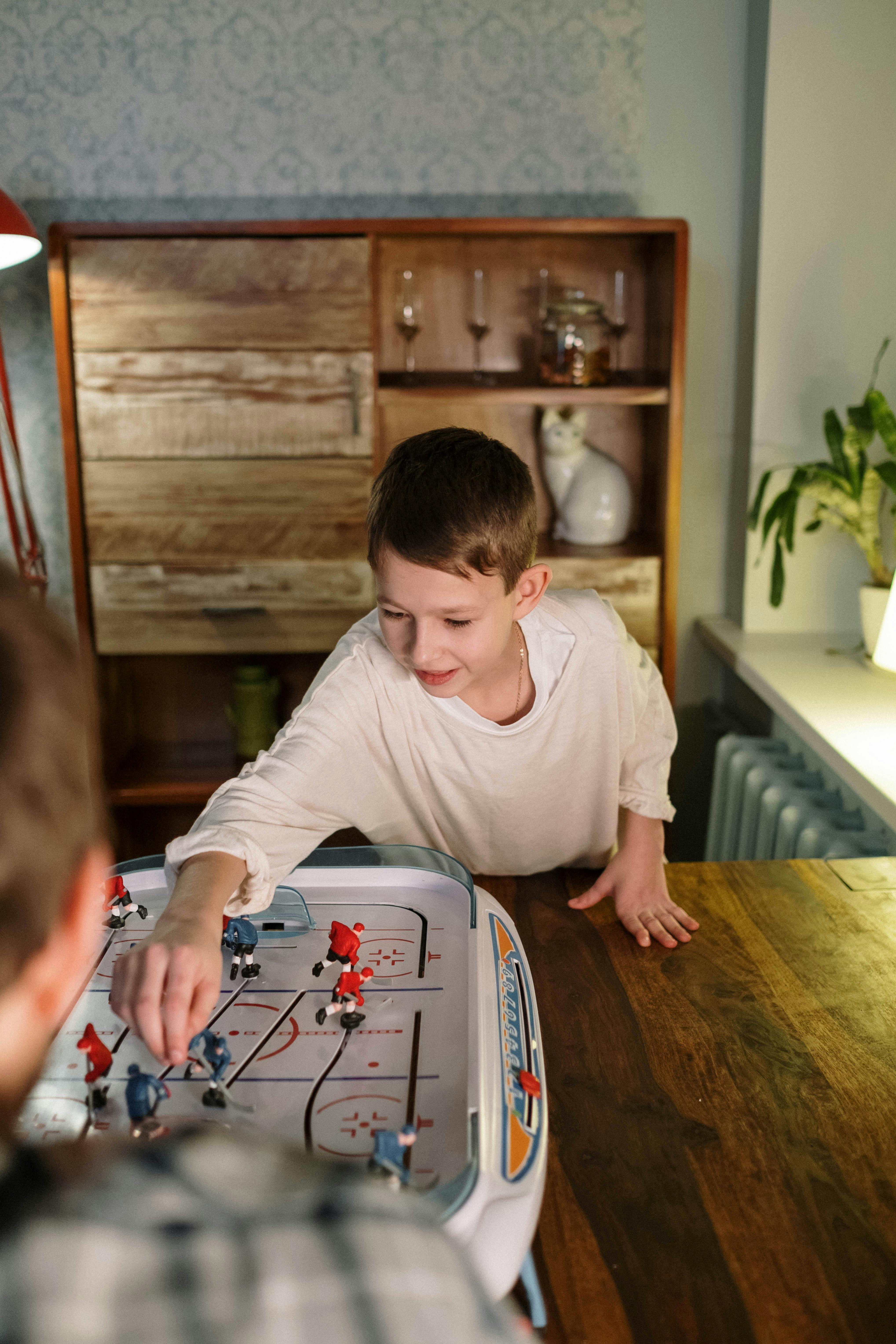 Photograph of a Boy Playing Table Hockey · Free Stock Photo