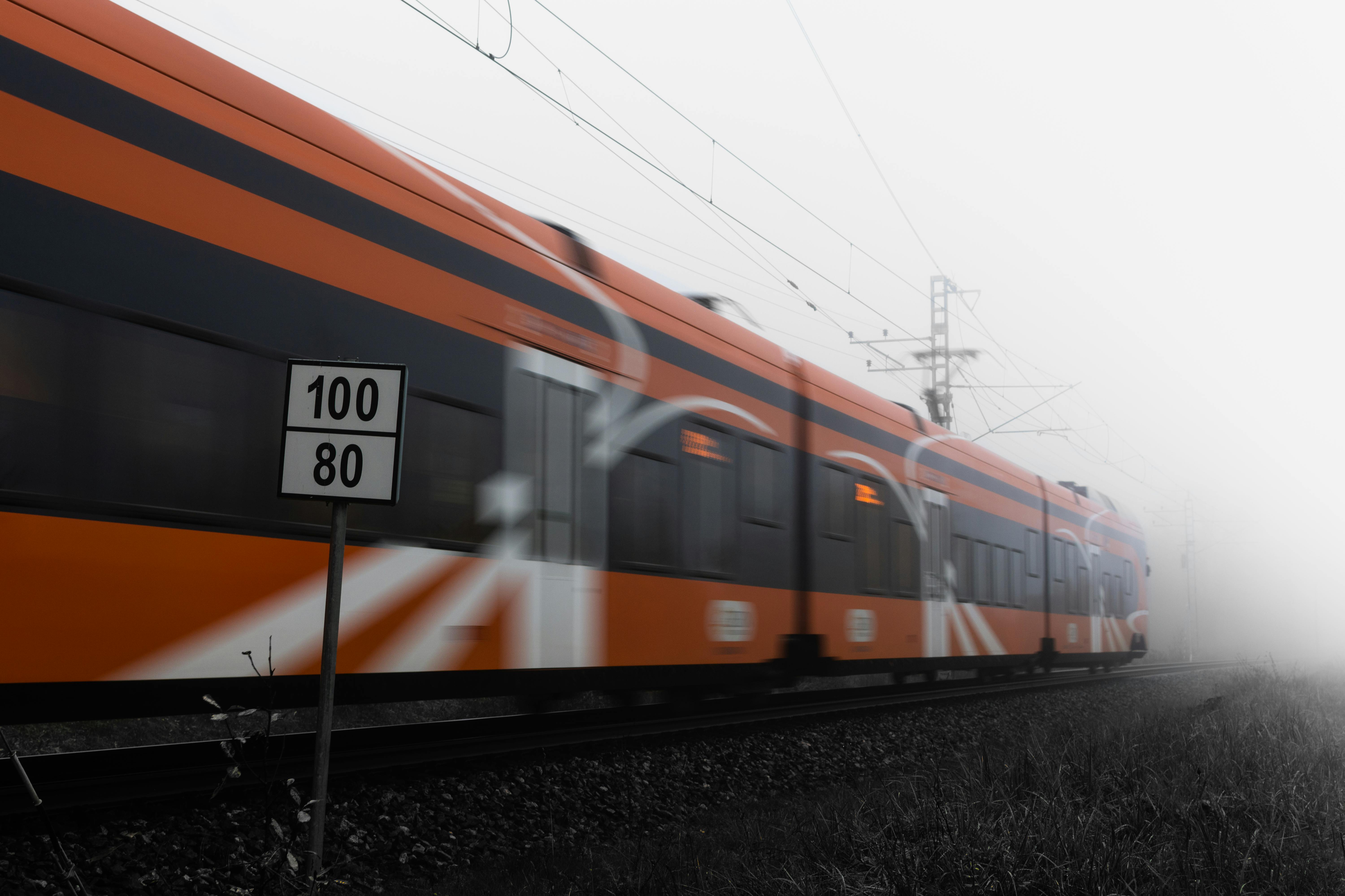 Orange Train on Rail Tracks · Free Stock Photo