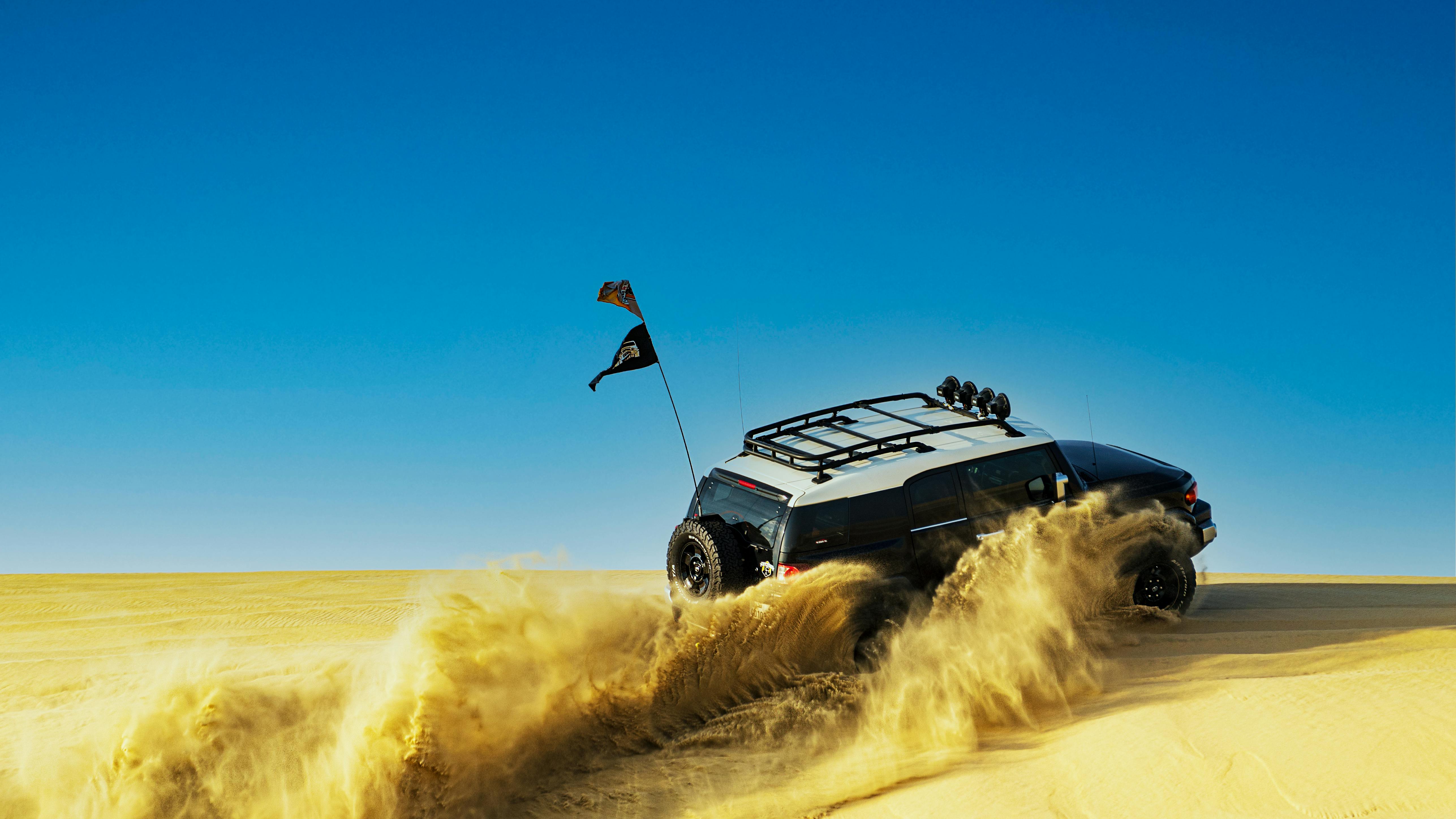 Contemporary SUV car drifting on sandy dune in desert · Free Stock Photo