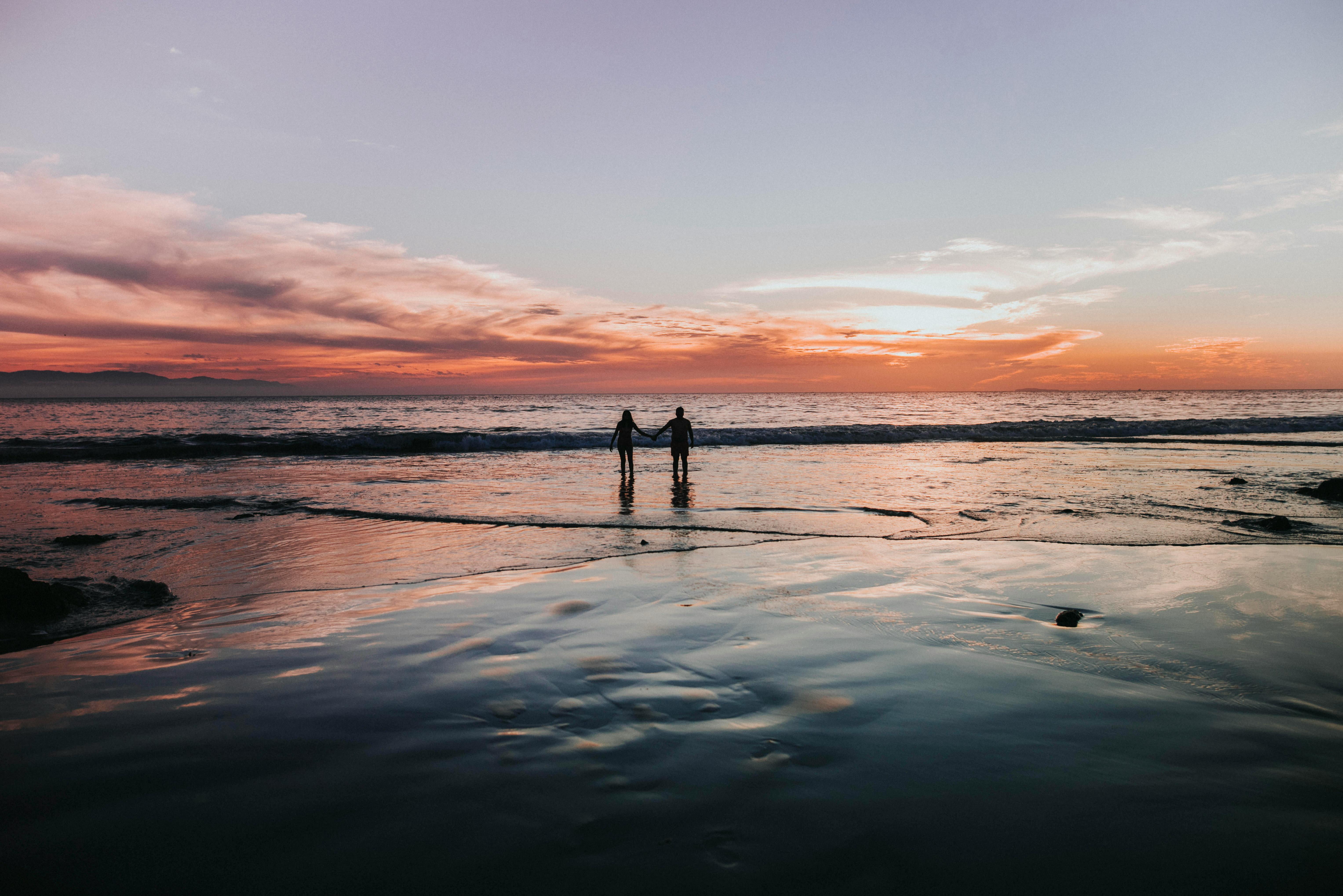 Silhouette of People Standing on Beach during Sunset · Free Stock Photo