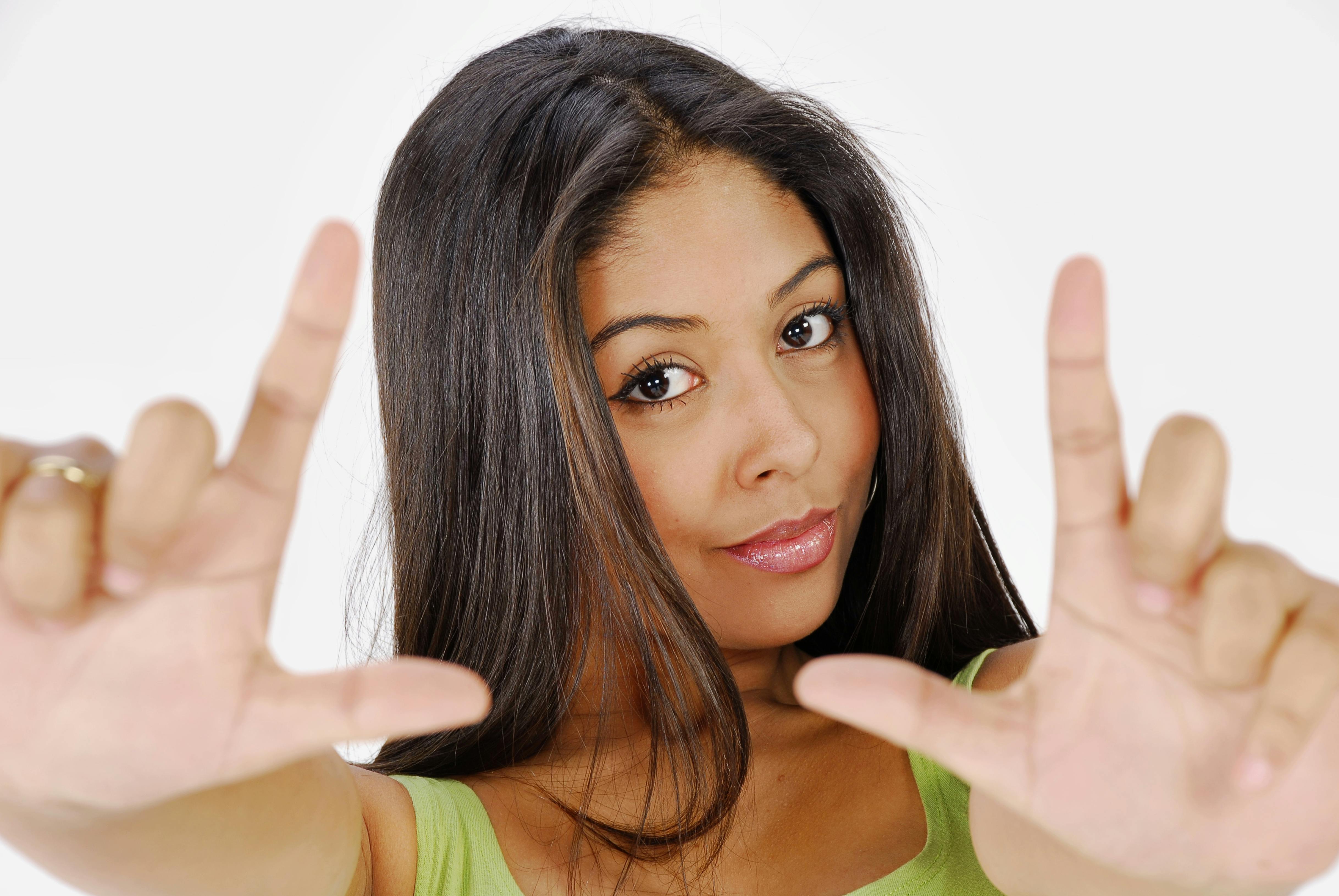 Woman in Green Tank Top Doing a Hand Gesture · Free Stock Photo