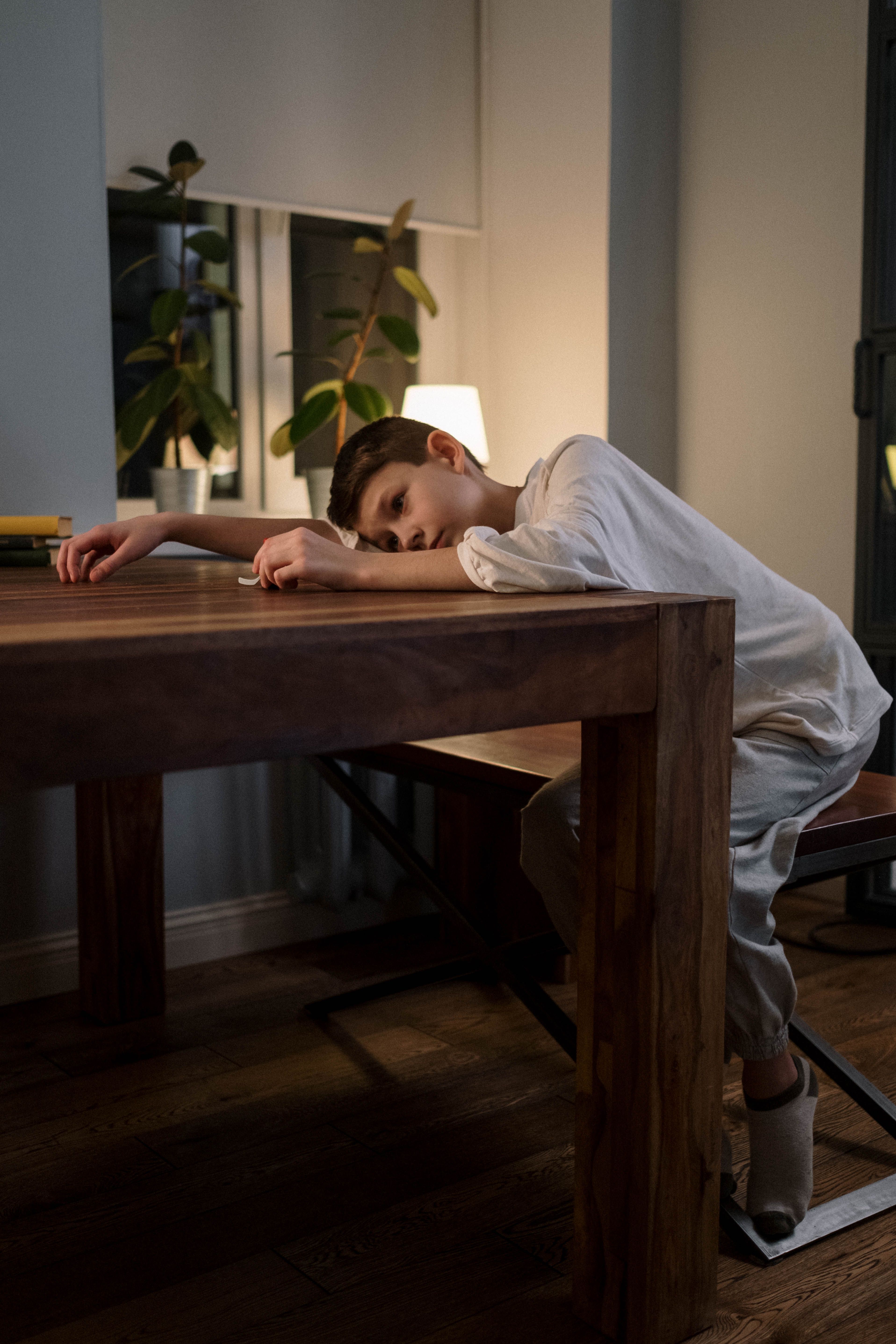 A Boy Resting His Face on Wooden Table · Free Stock Photo