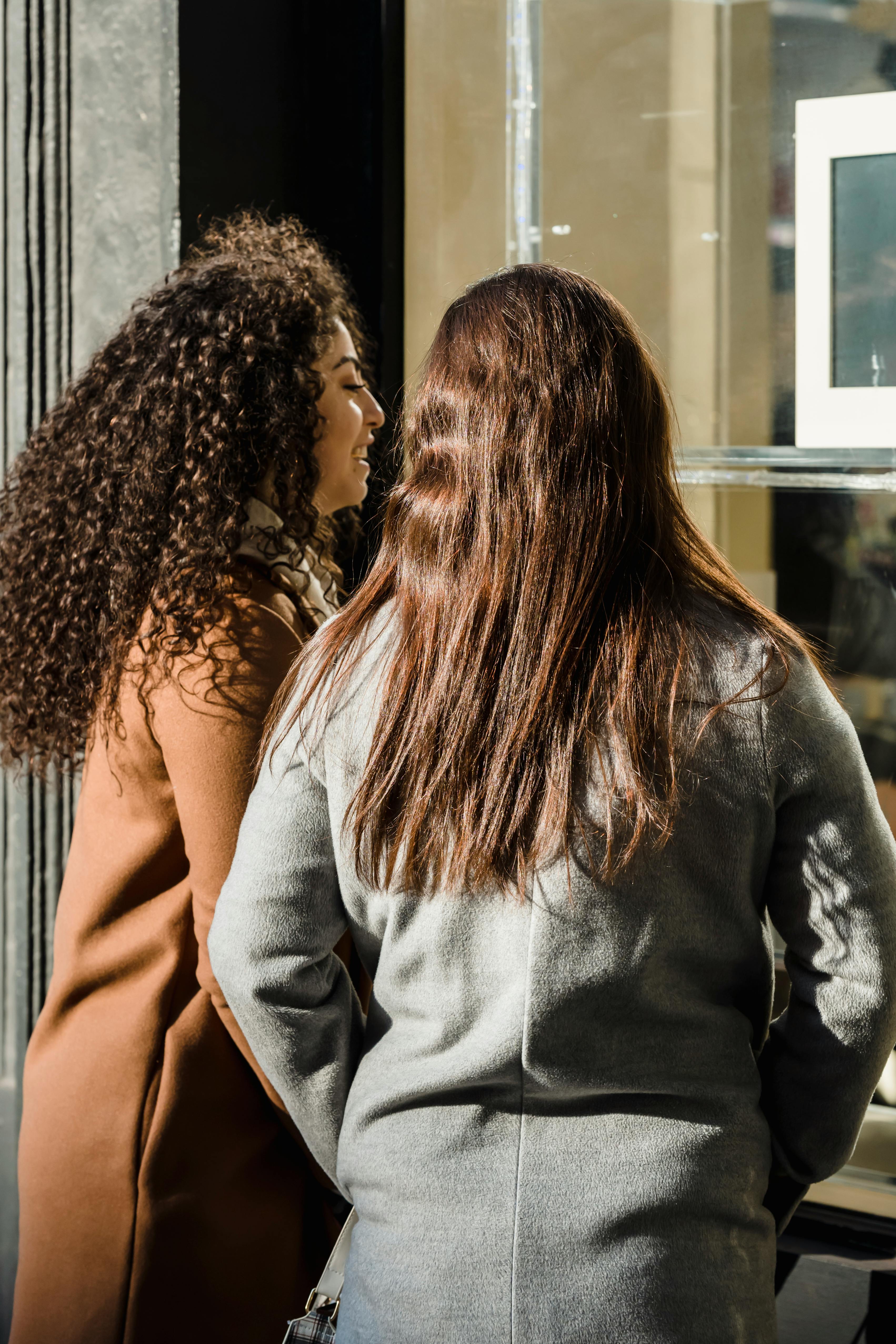 Anonymous women standing near showcase · Free Stock Photo