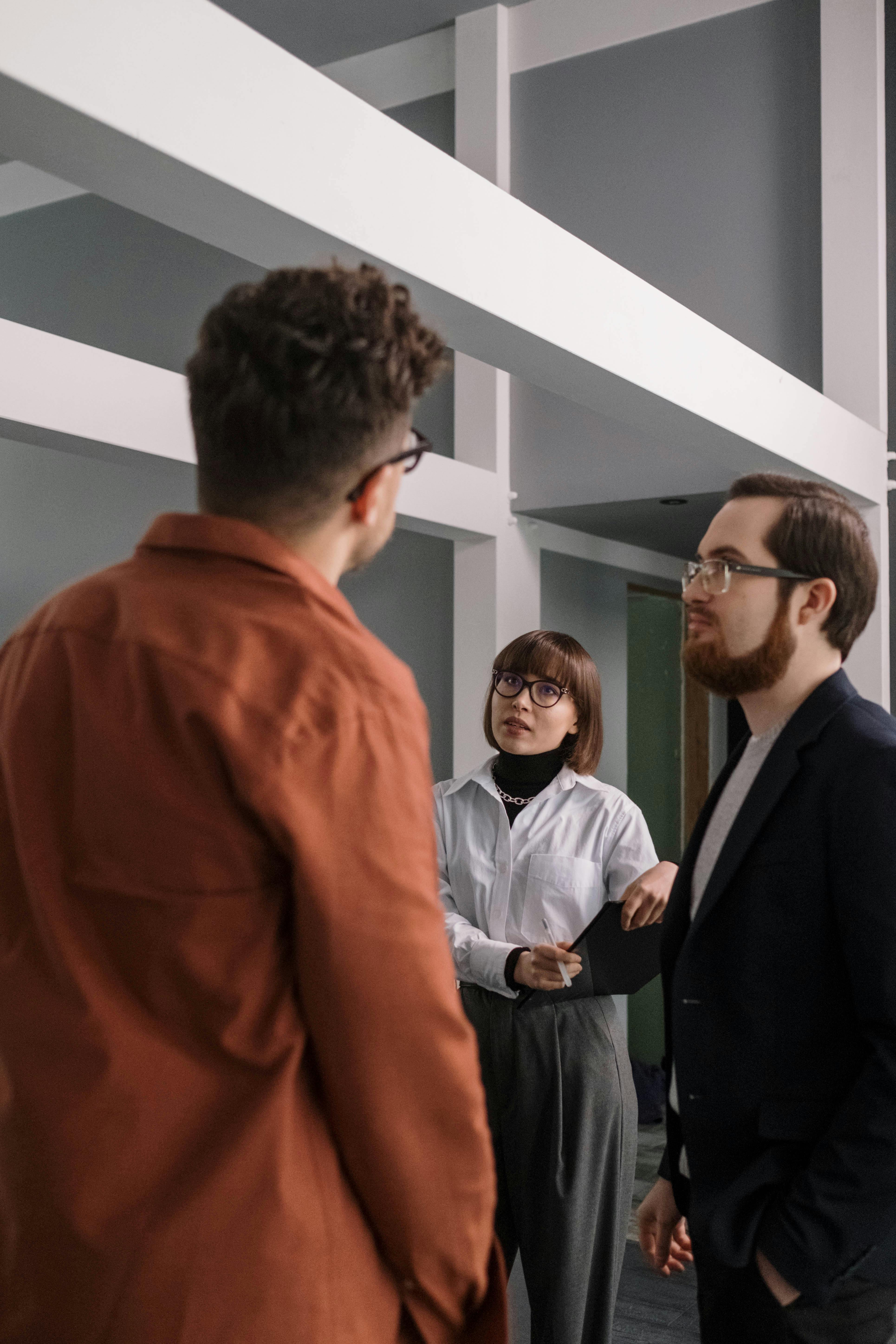 Three People Talking in an Office · Free Stock Photo