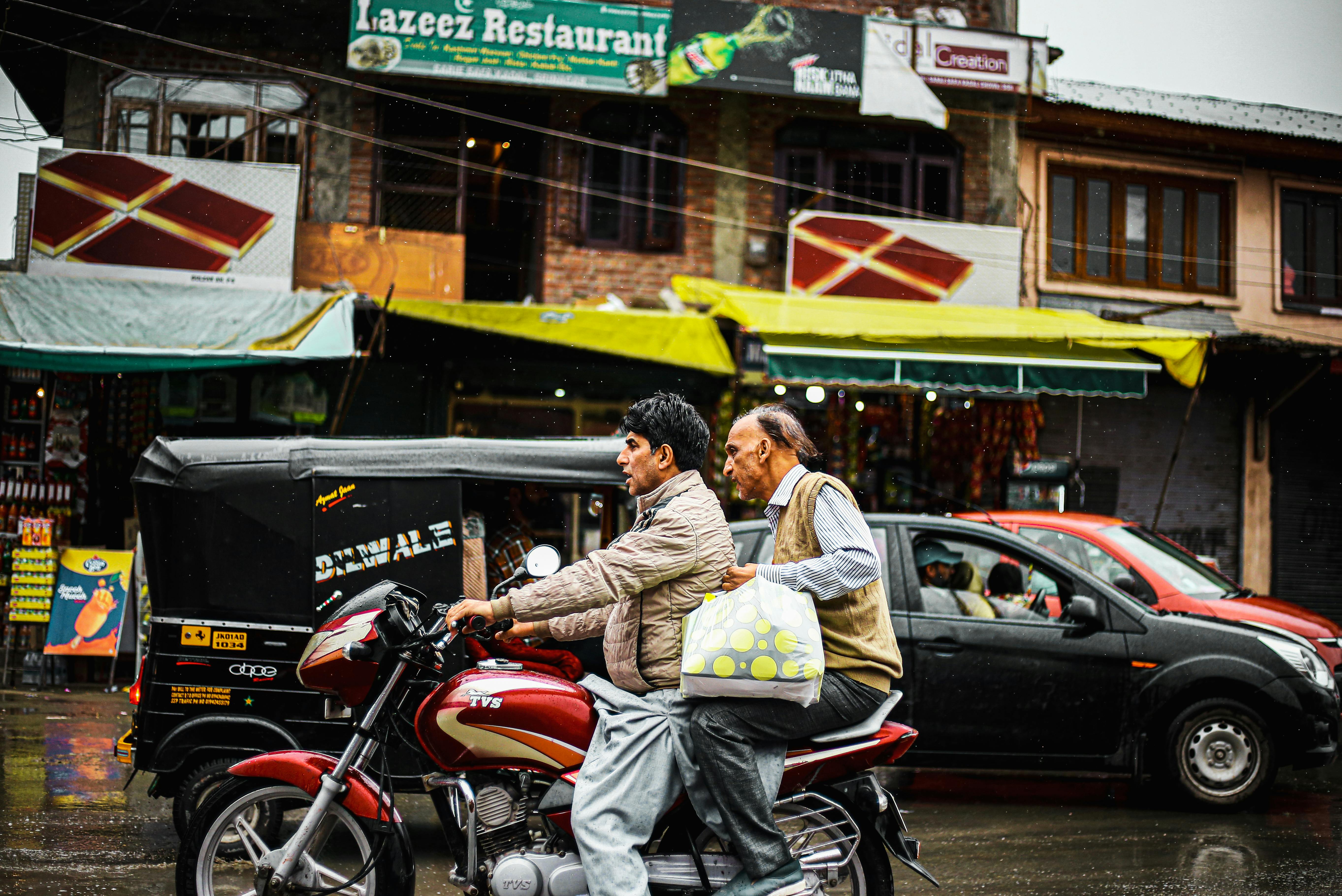 Salesman Looking at the Black Motorcycle · Free Stock Photo