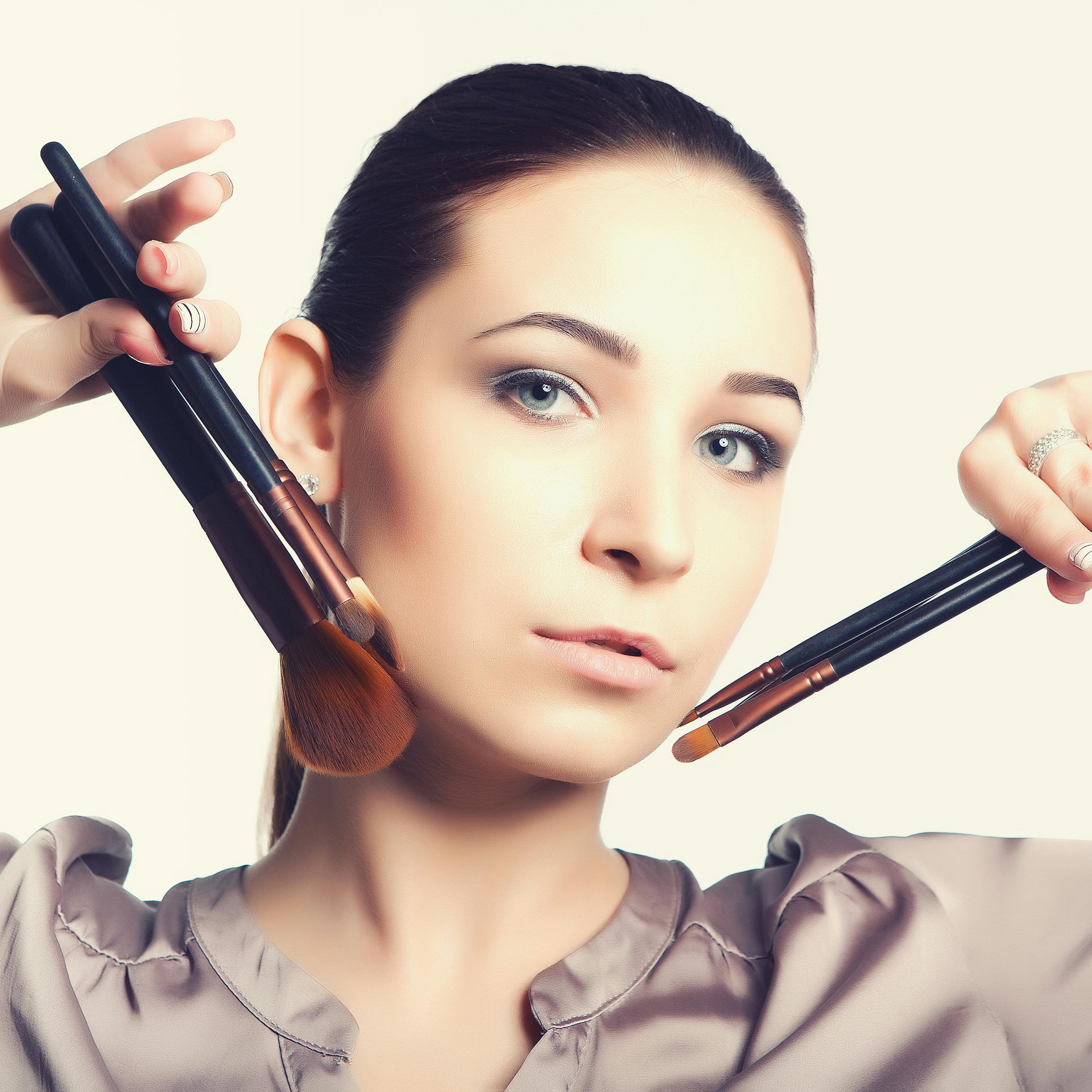 Beautiful Woman Holding Makeup Brushes · Free Stock Photo
