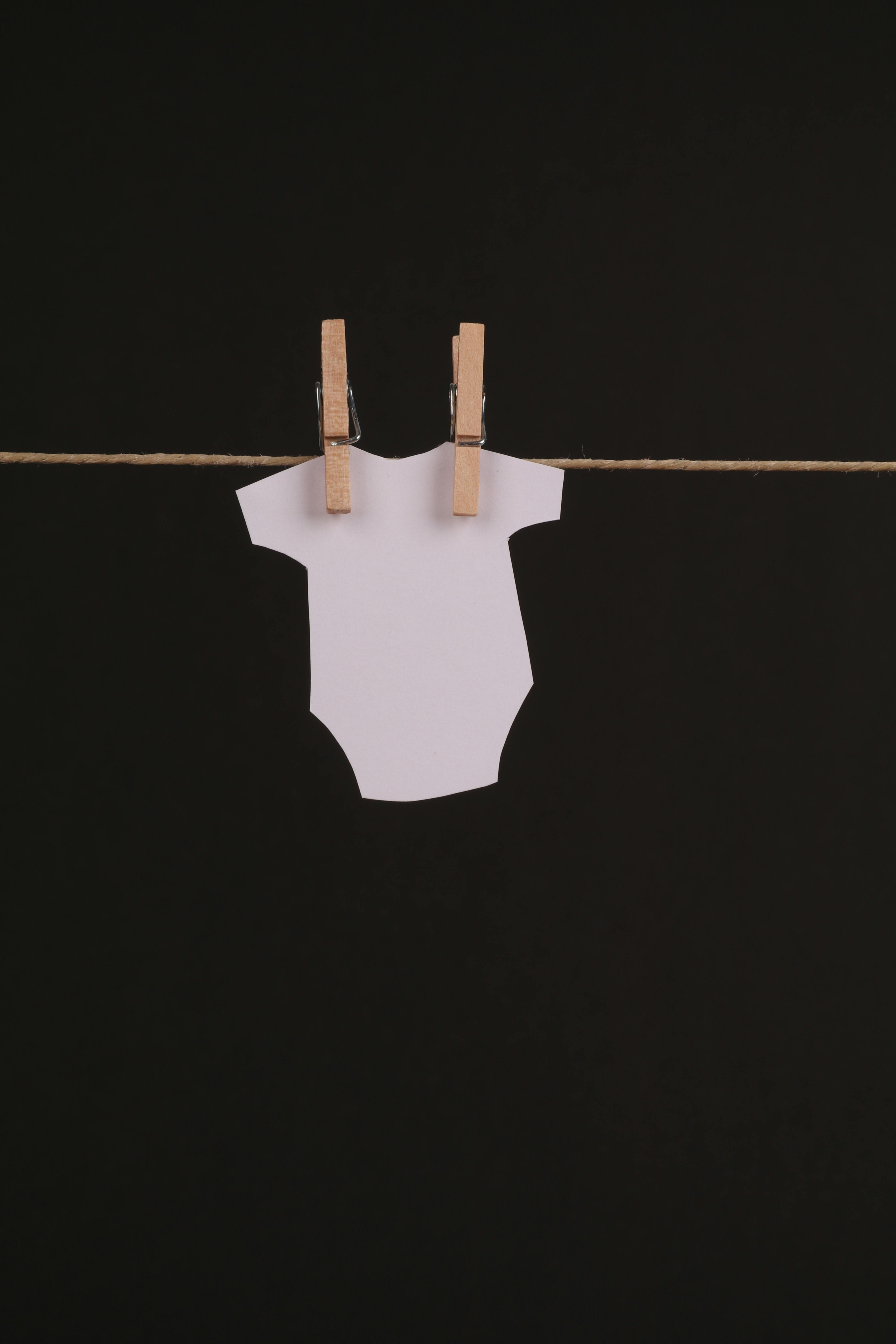 Paper Shape of Baby Uniform Attached to String · Free Stock Photo