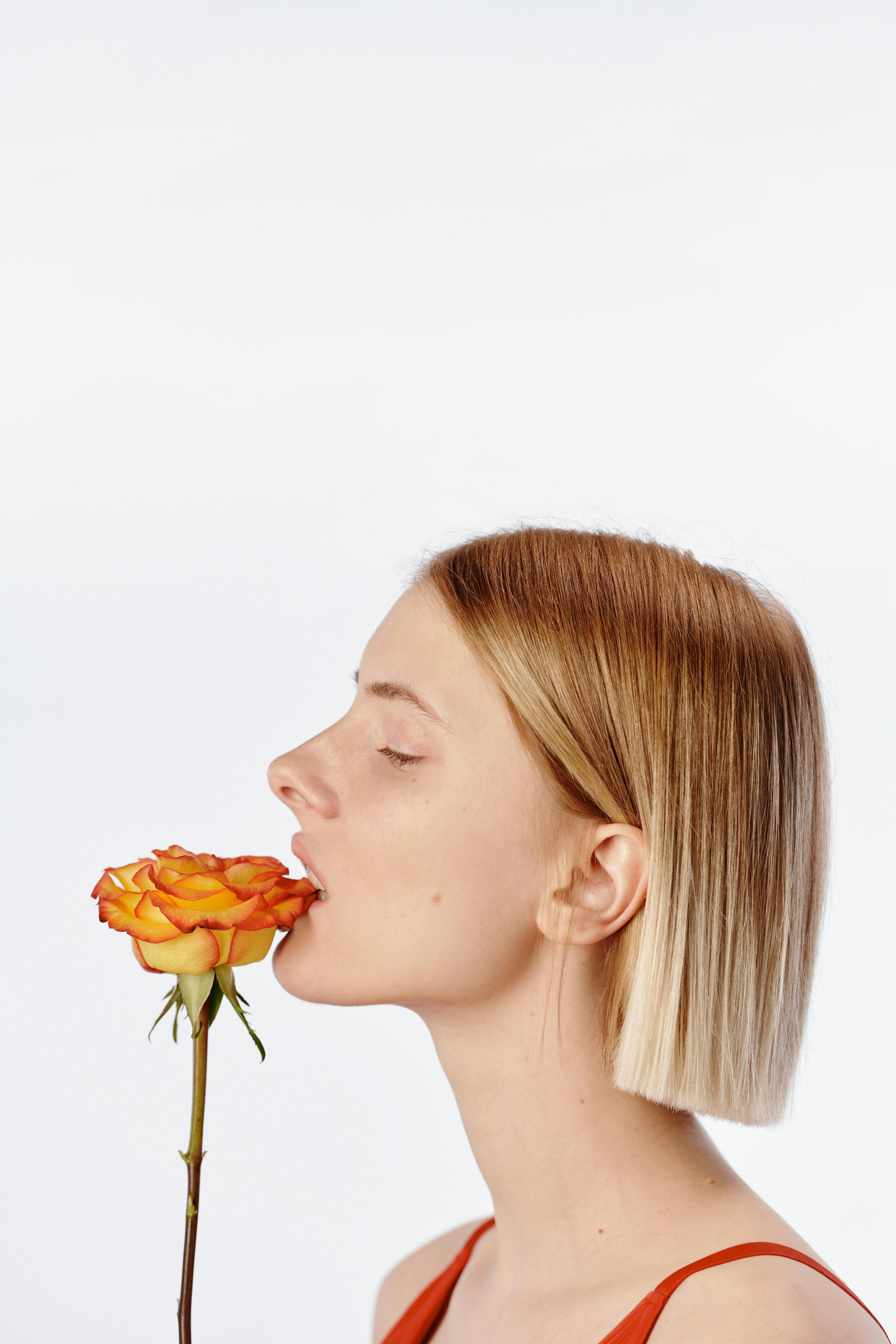 A Young Woman Biting a Flower · Free Stock Photo