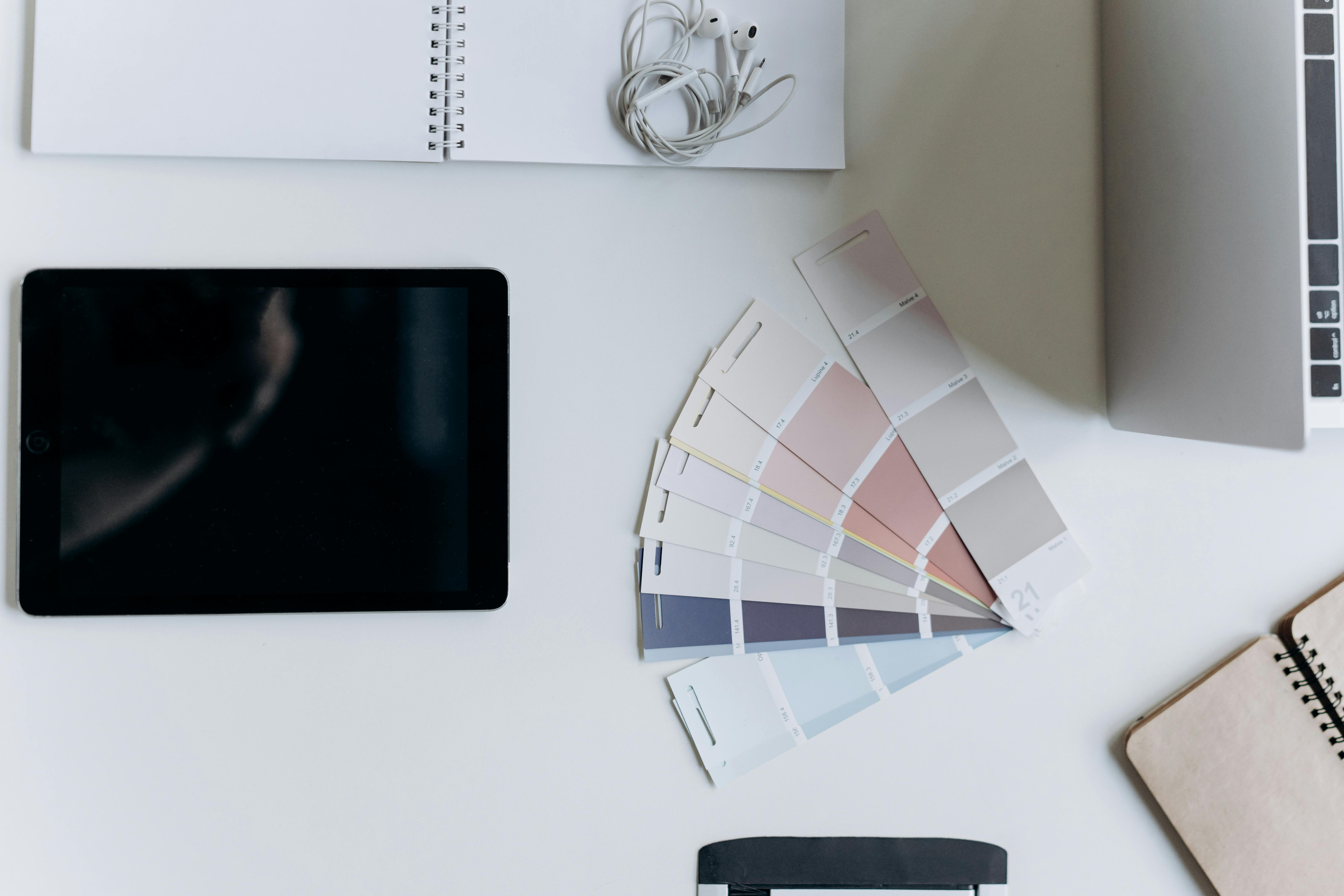 Electronic Gadgets and Spiral Notebooks on a Table · Free Stock Photo