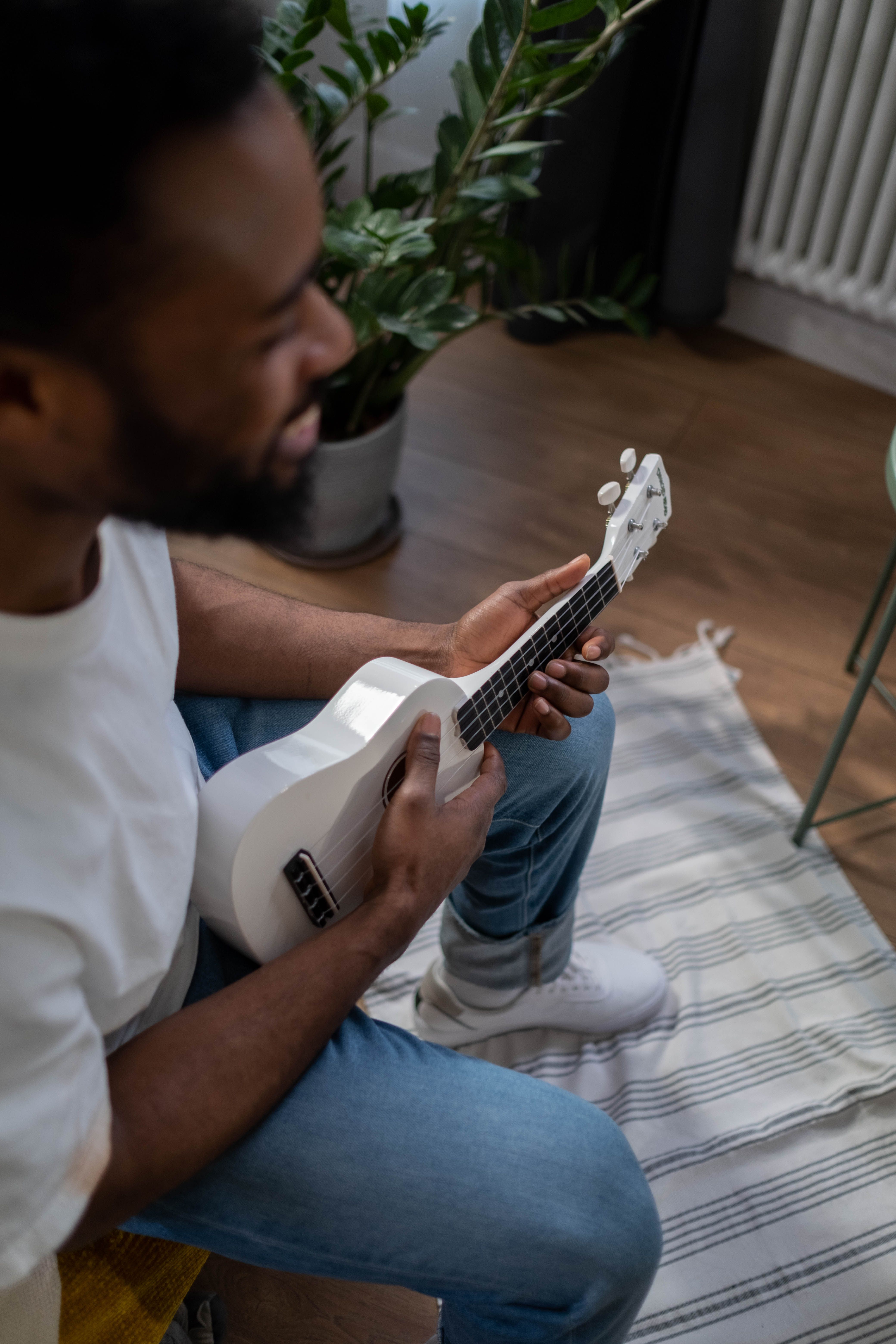 Photo of a Woman Standing Beside a Man Playing a Ukulele · Free Stock Photo