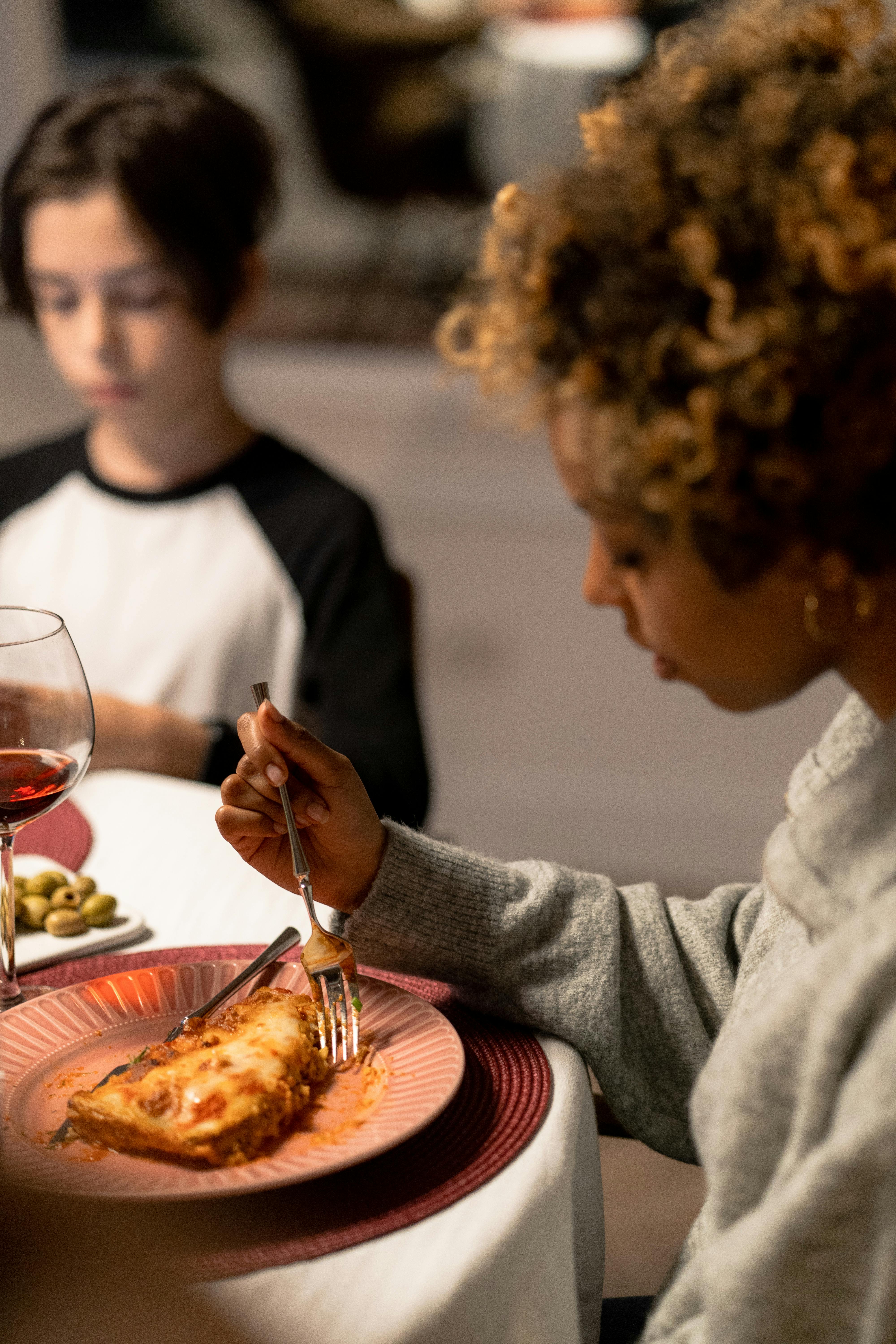 A Woman Sitting at a Table Eating · Free Stock Photo
