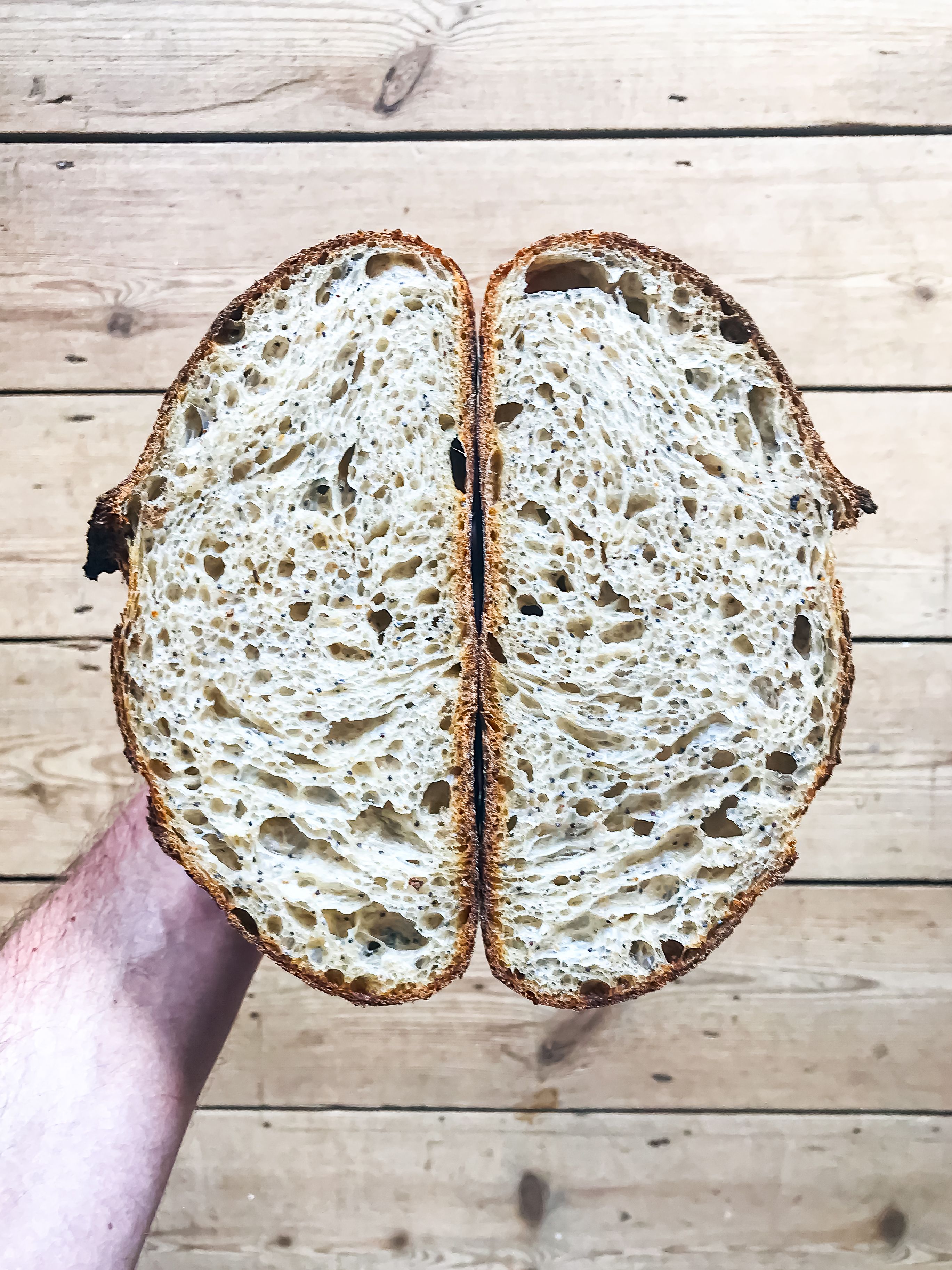 Crop unrecognizable person showing fresh cut bread · Free Stock Photo