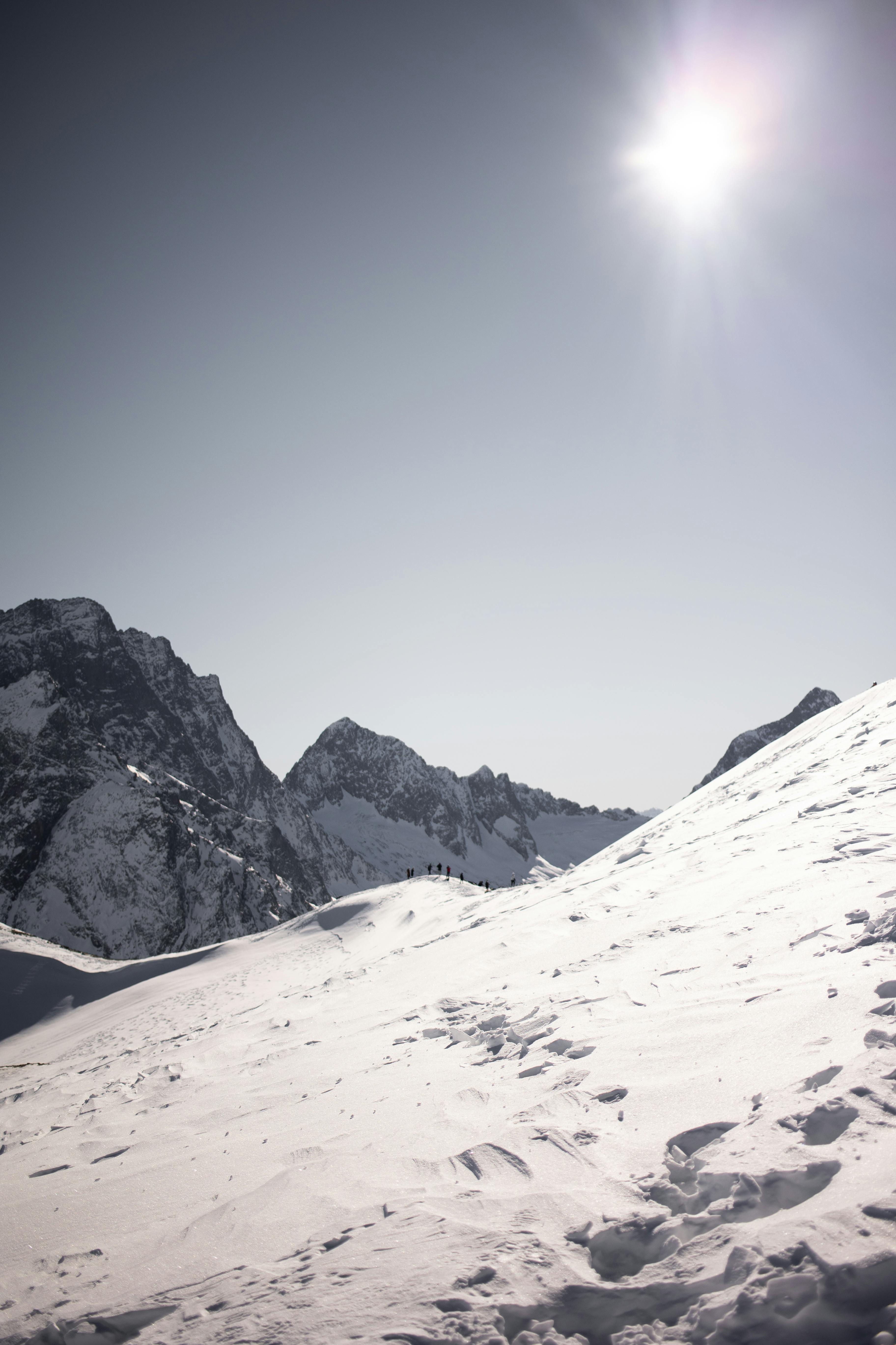 People Walking on a Snow Covered Mountain Under a Bright Sun · Free ...