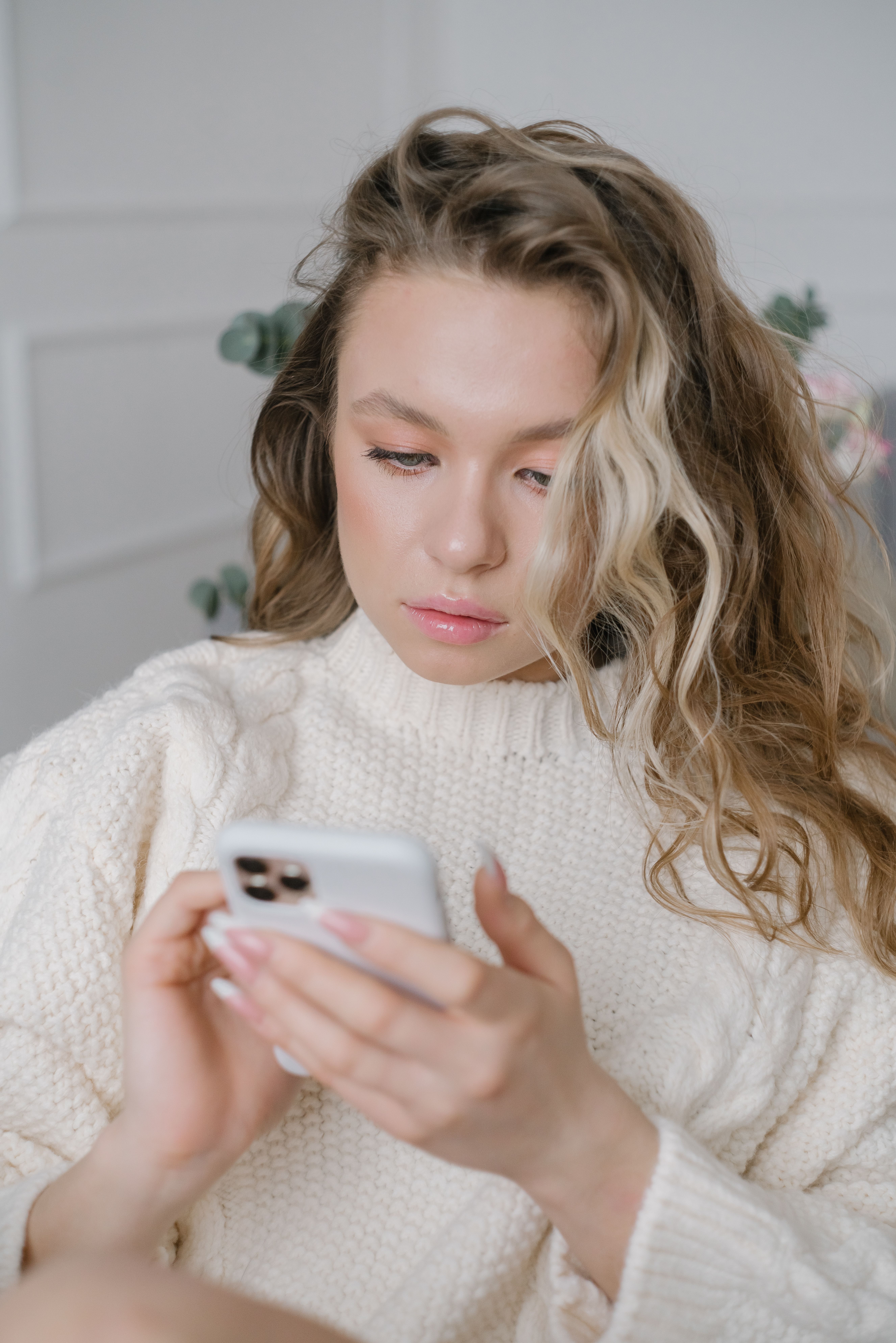 A Woman in White Knit Sweater Holding a Smartphone · Free Stock Photo