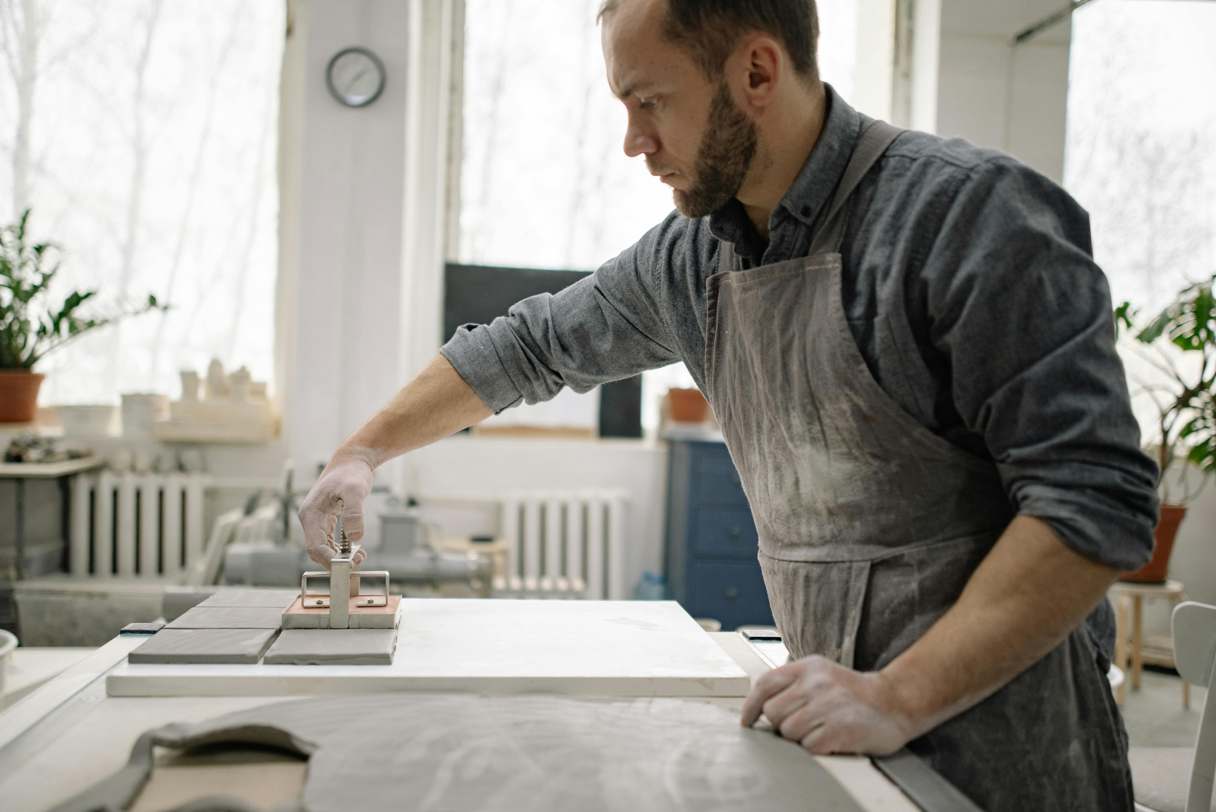 Man Working in a Workshop and Using Machinery · Free Stock Photo