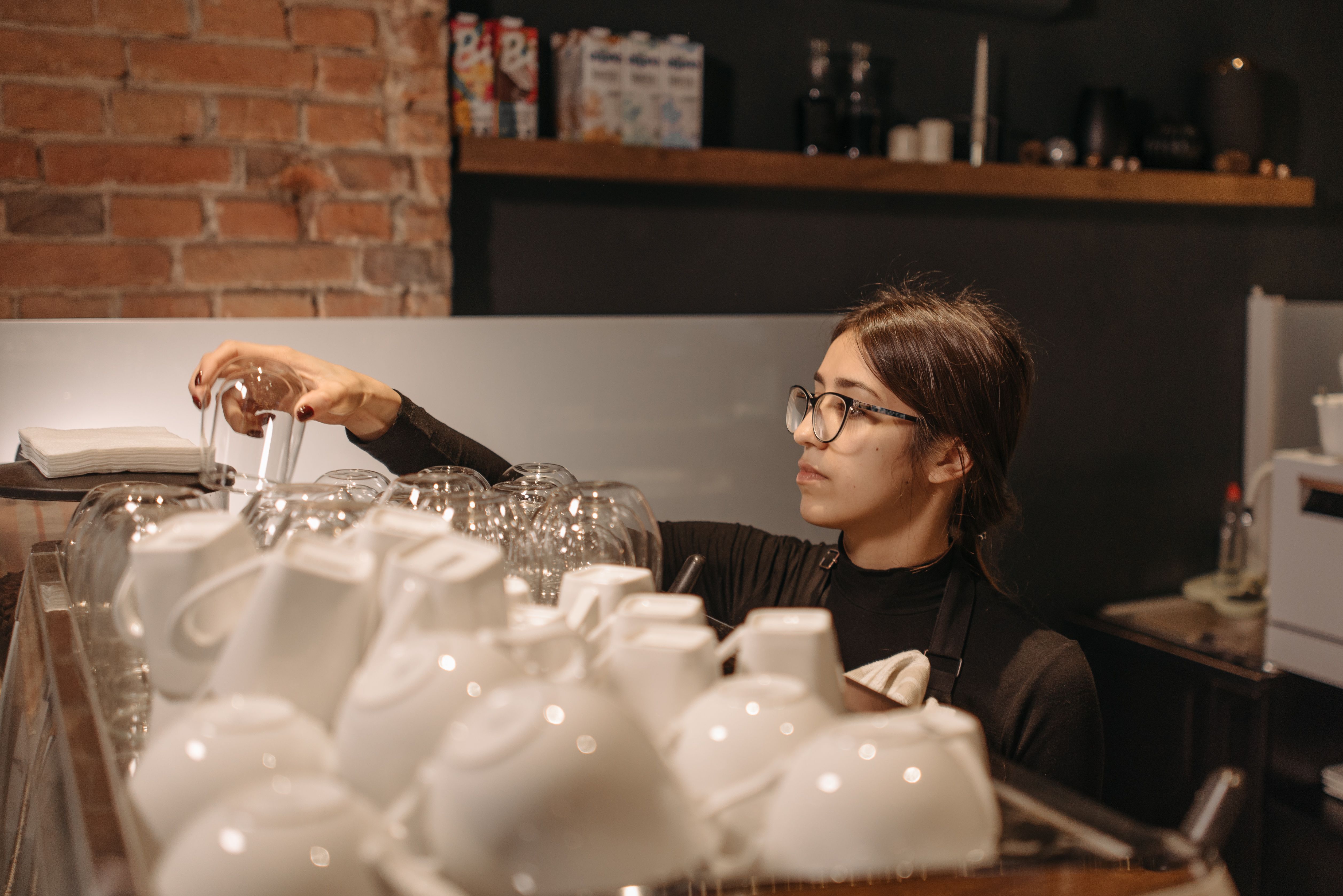 A Woman Arranging Cups and Mugs · Free Stock Photo