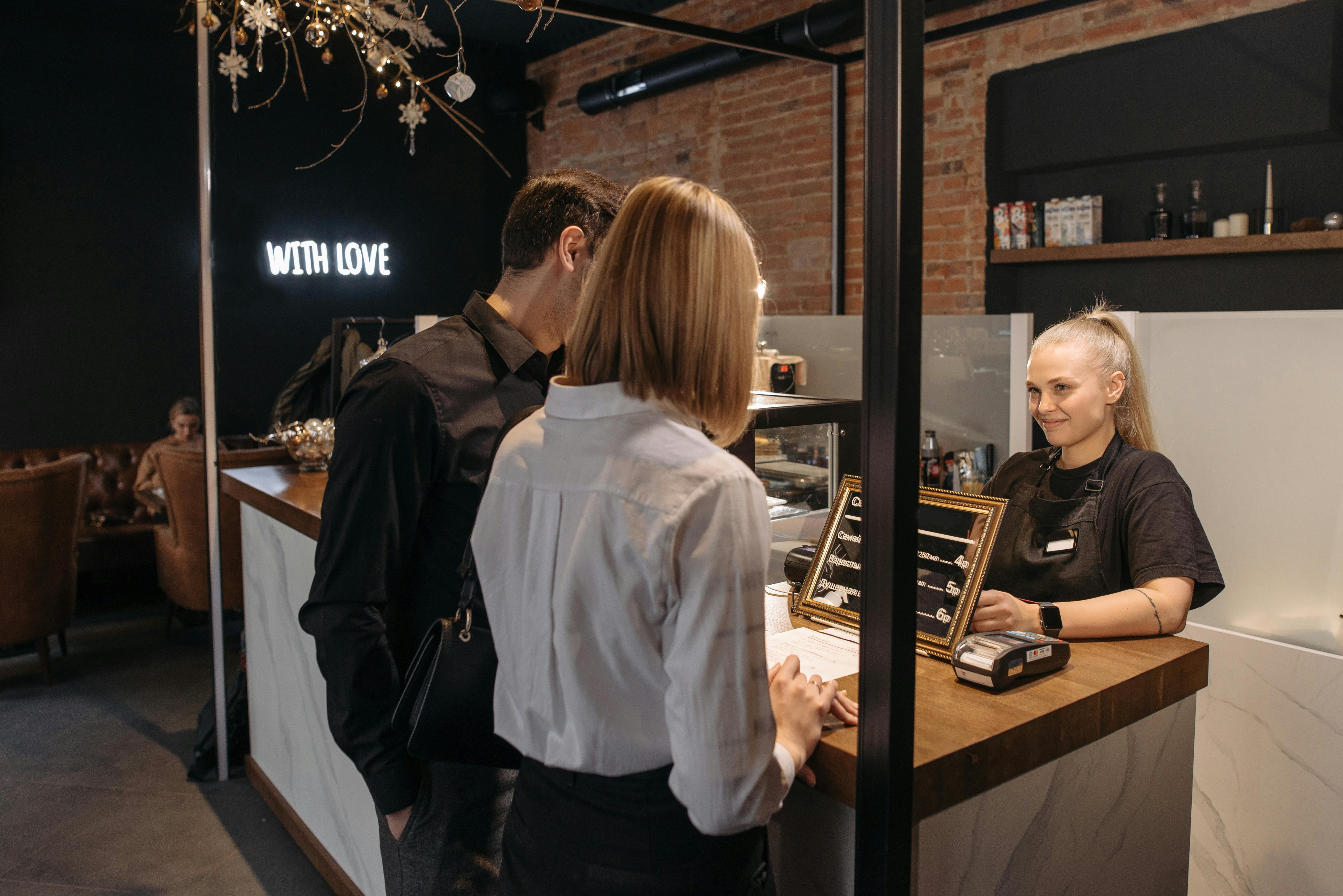 A Woman Standing Behind the Counter of a Coffee Shop · Free Stock Photo