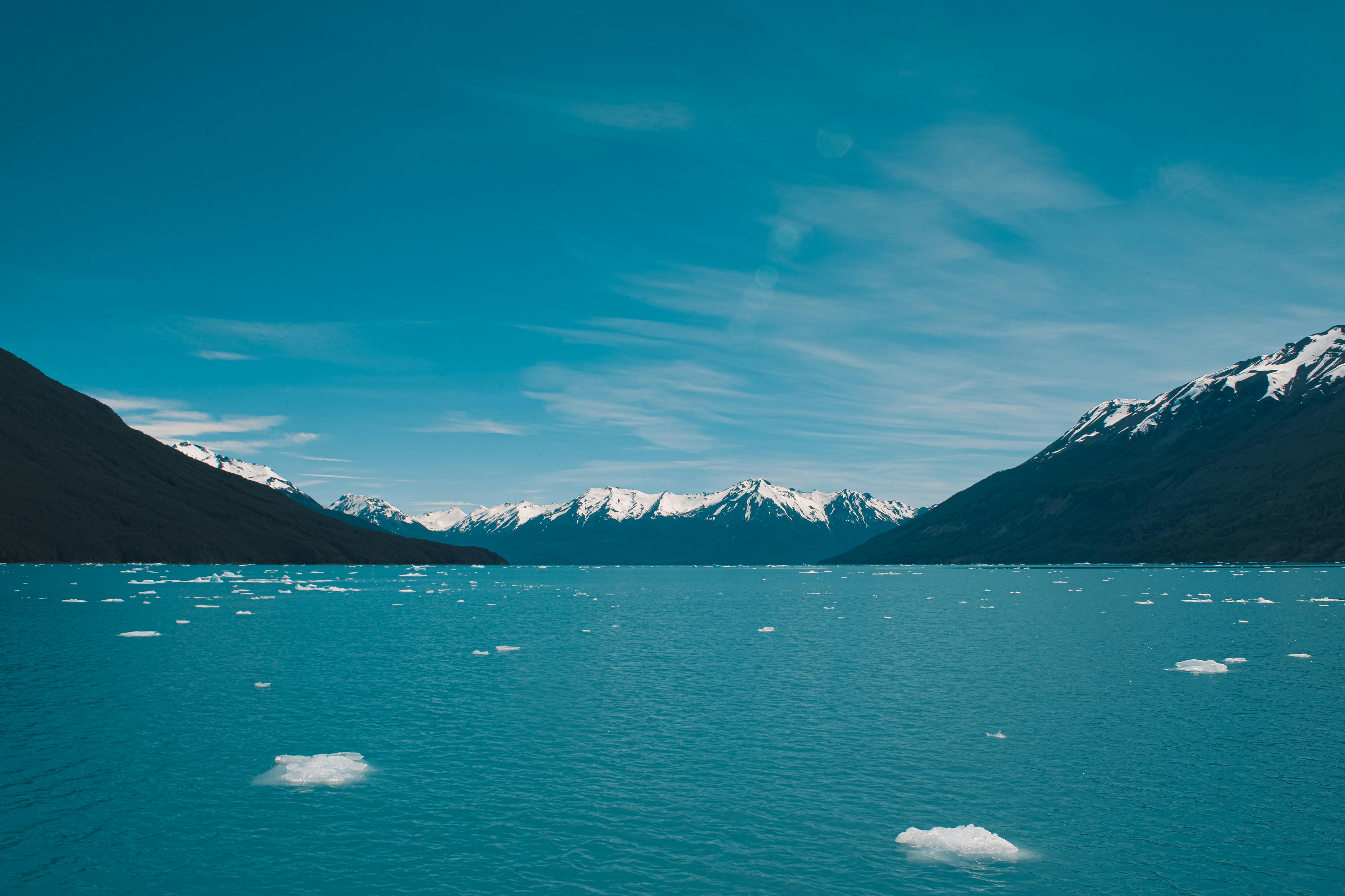Blue Ocean Near Mountain Under Blue Sky · Free Stock Photo
