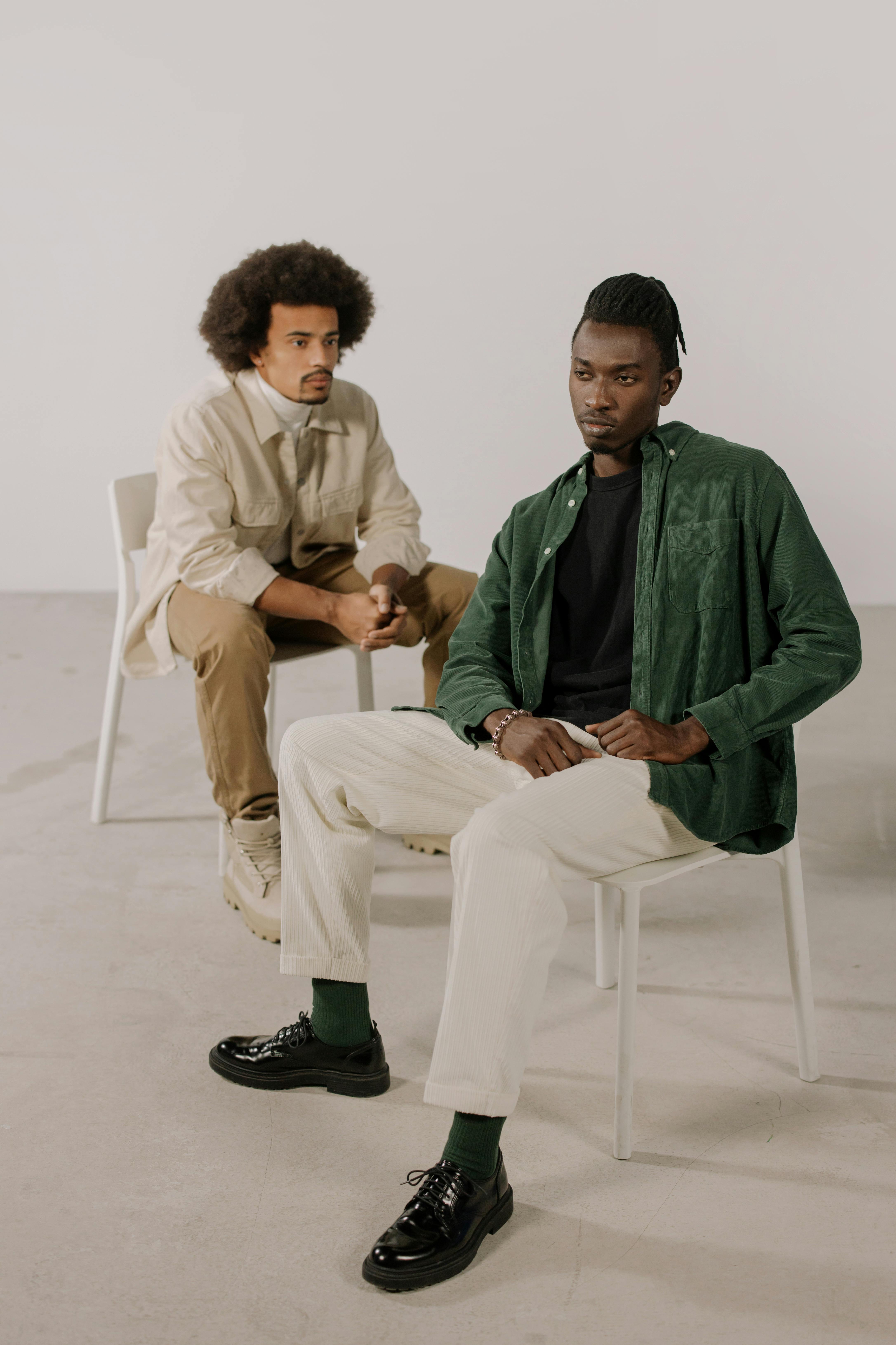 Two Young Men in Shirts and Slacks Sitting in Chairs · Free Stock Photo