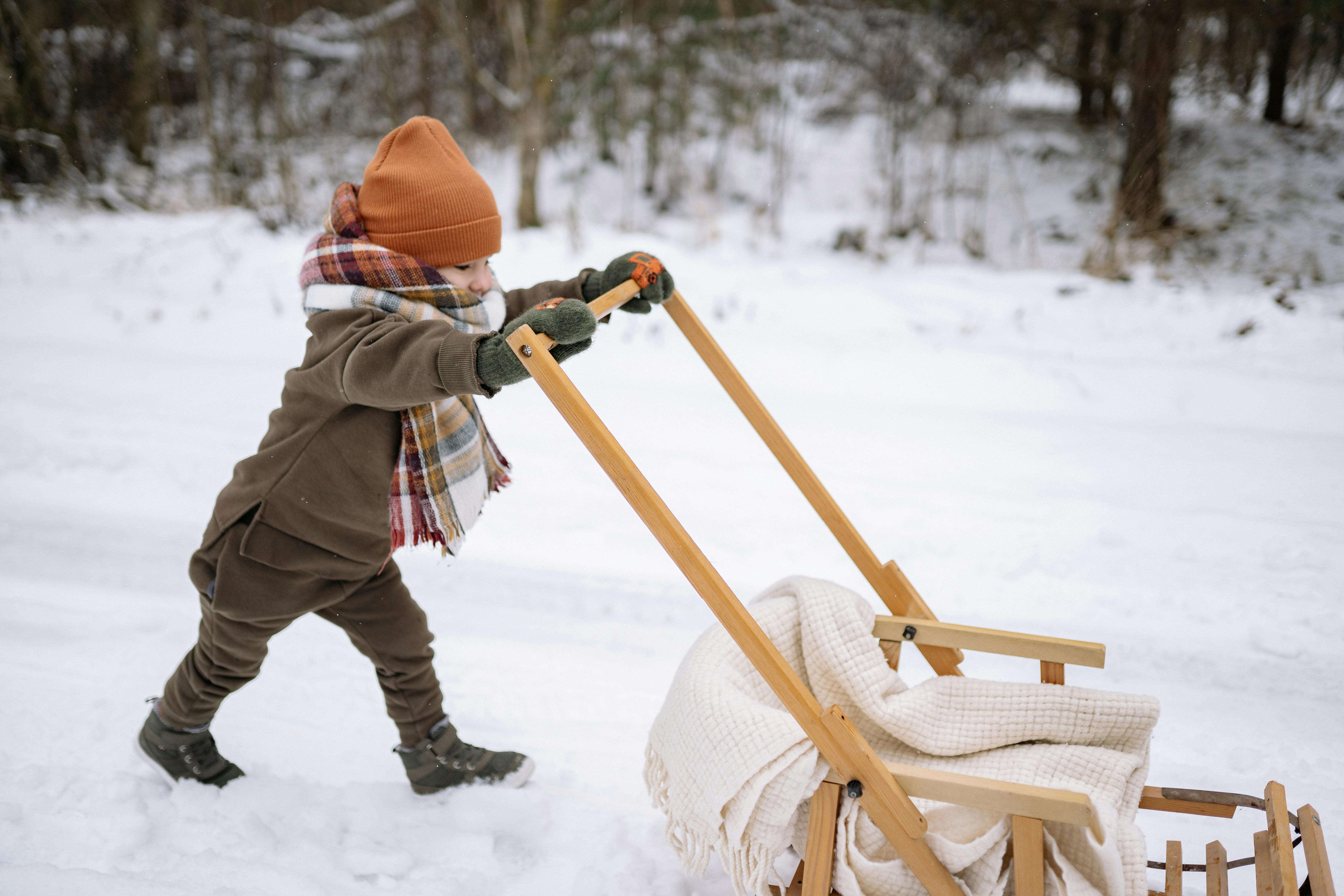 Little Child Pushing Sled in Winter · Free Stock Photo