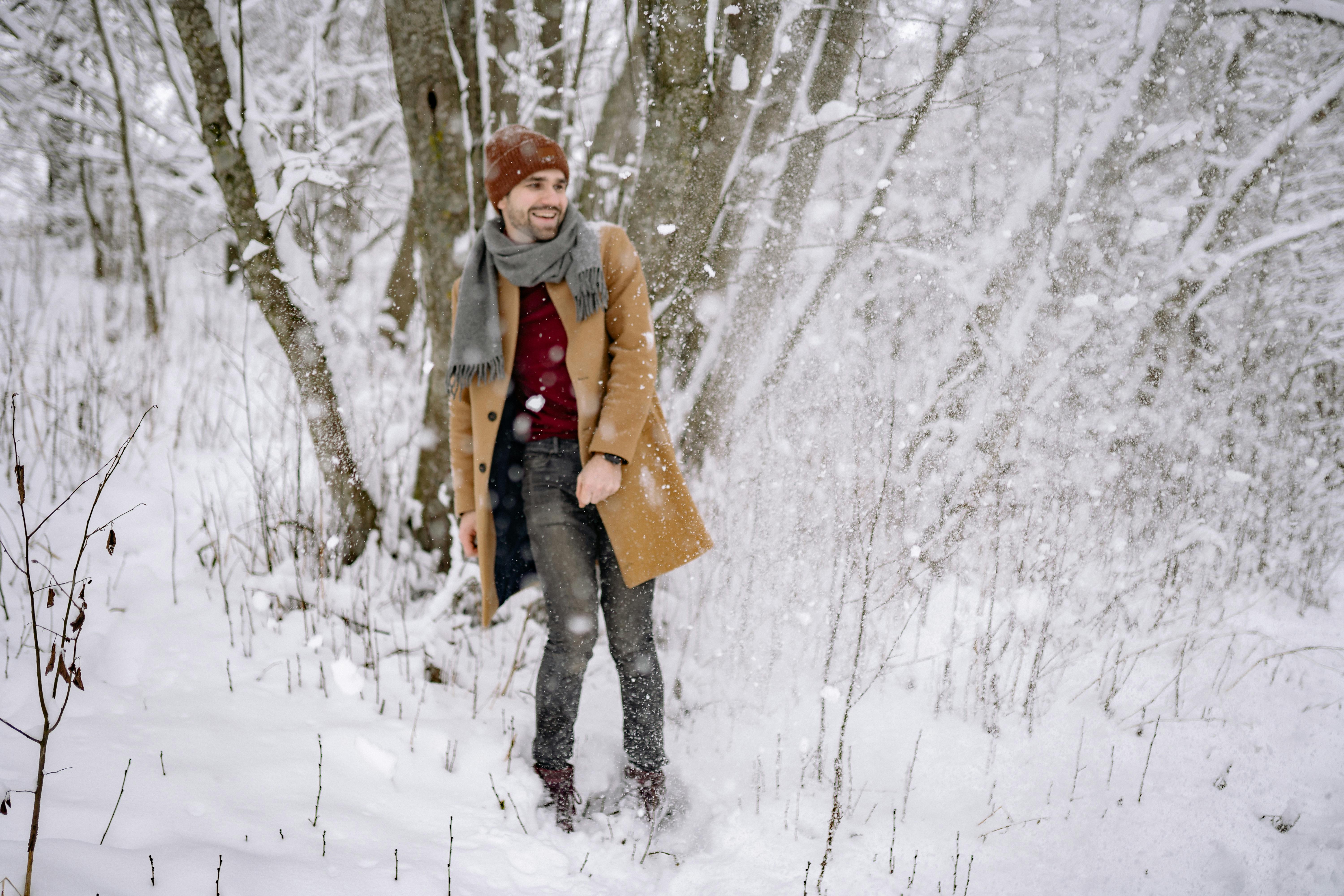 A Man Standing on the Snow Covered Ground with Trees · Free Stock Photo