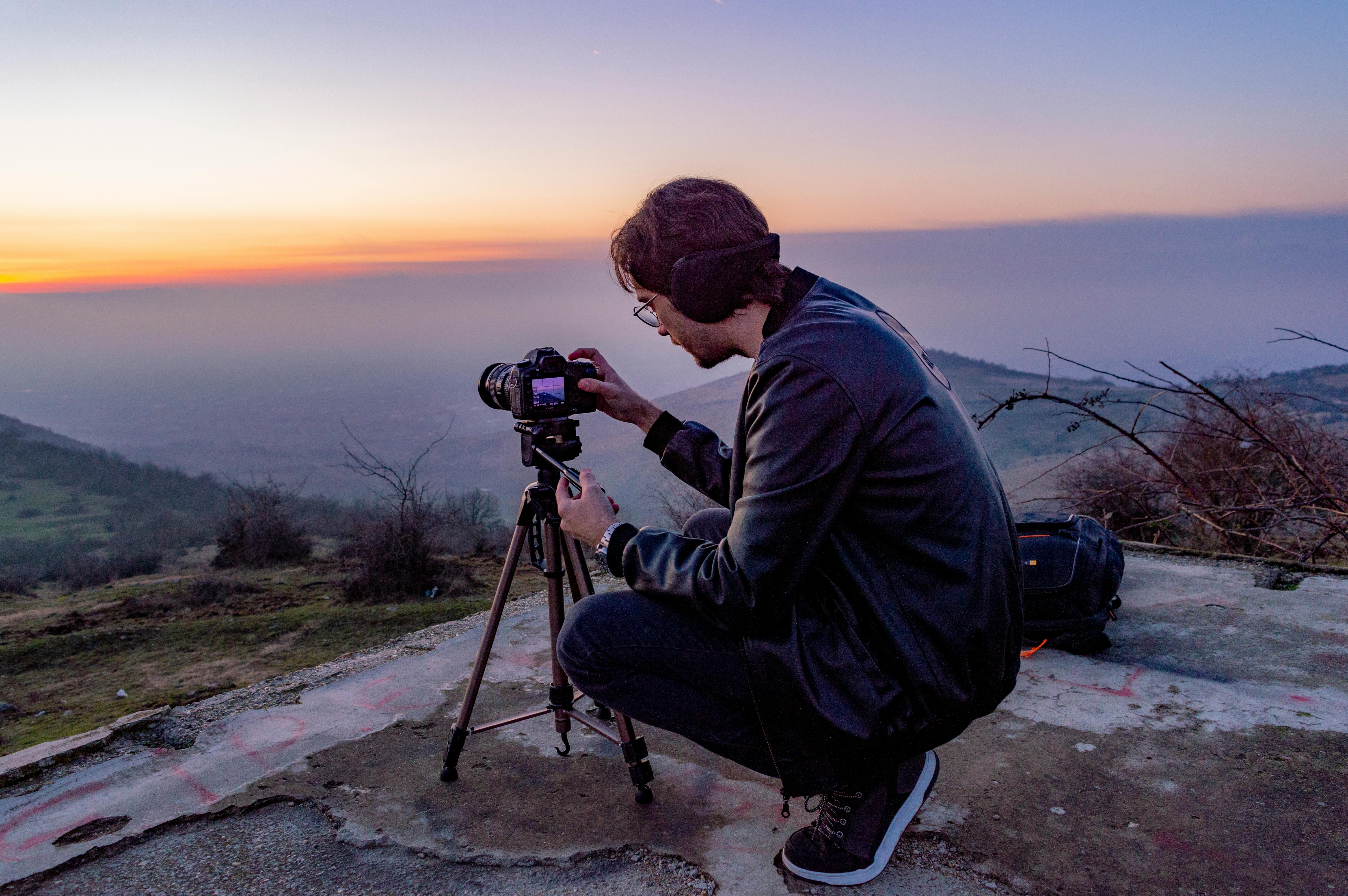 Man Using a Camera on a Tripod · Free Stock Photo