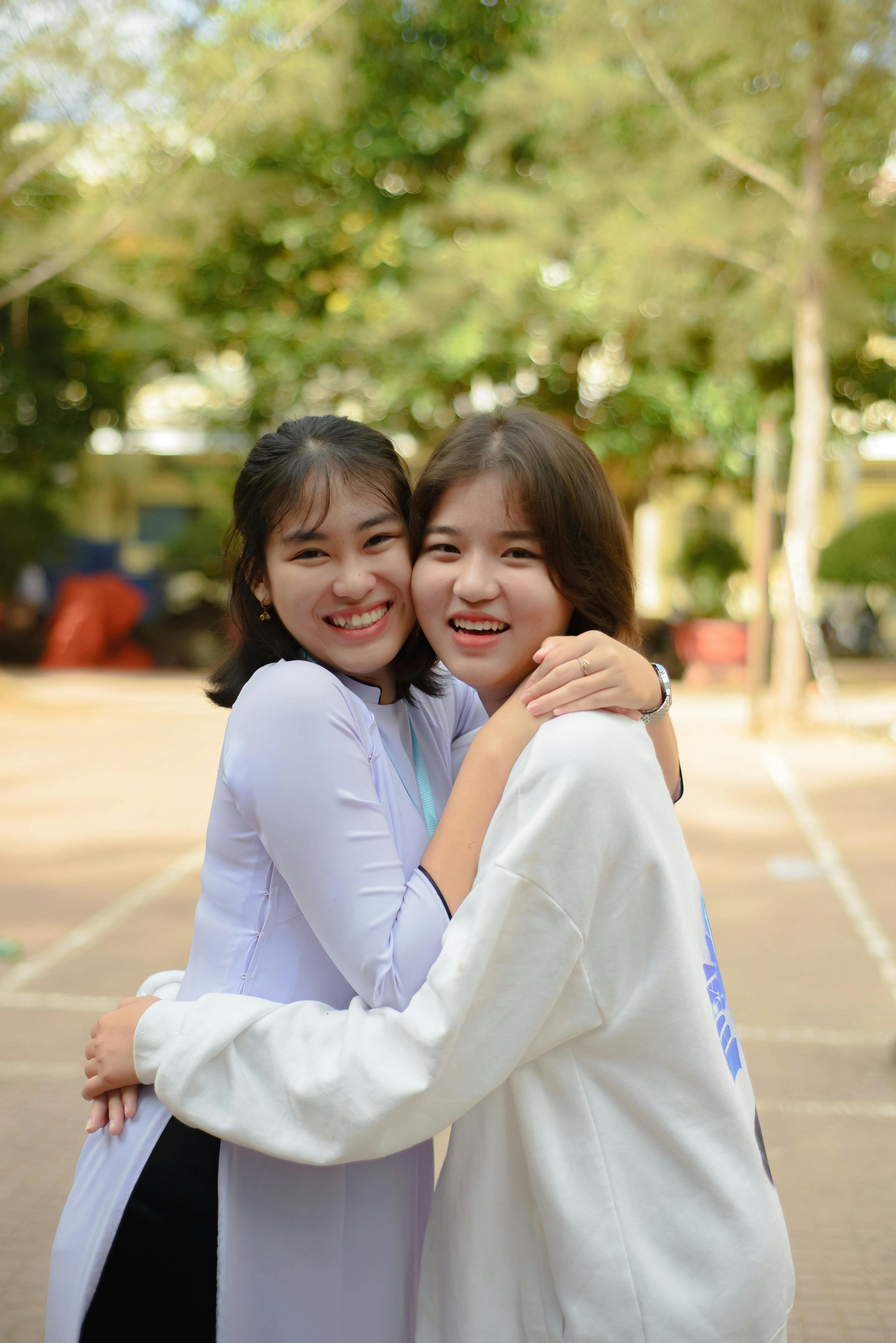 Portrait of Smiling Girls Hugging Outdoors · Free Stock Photo