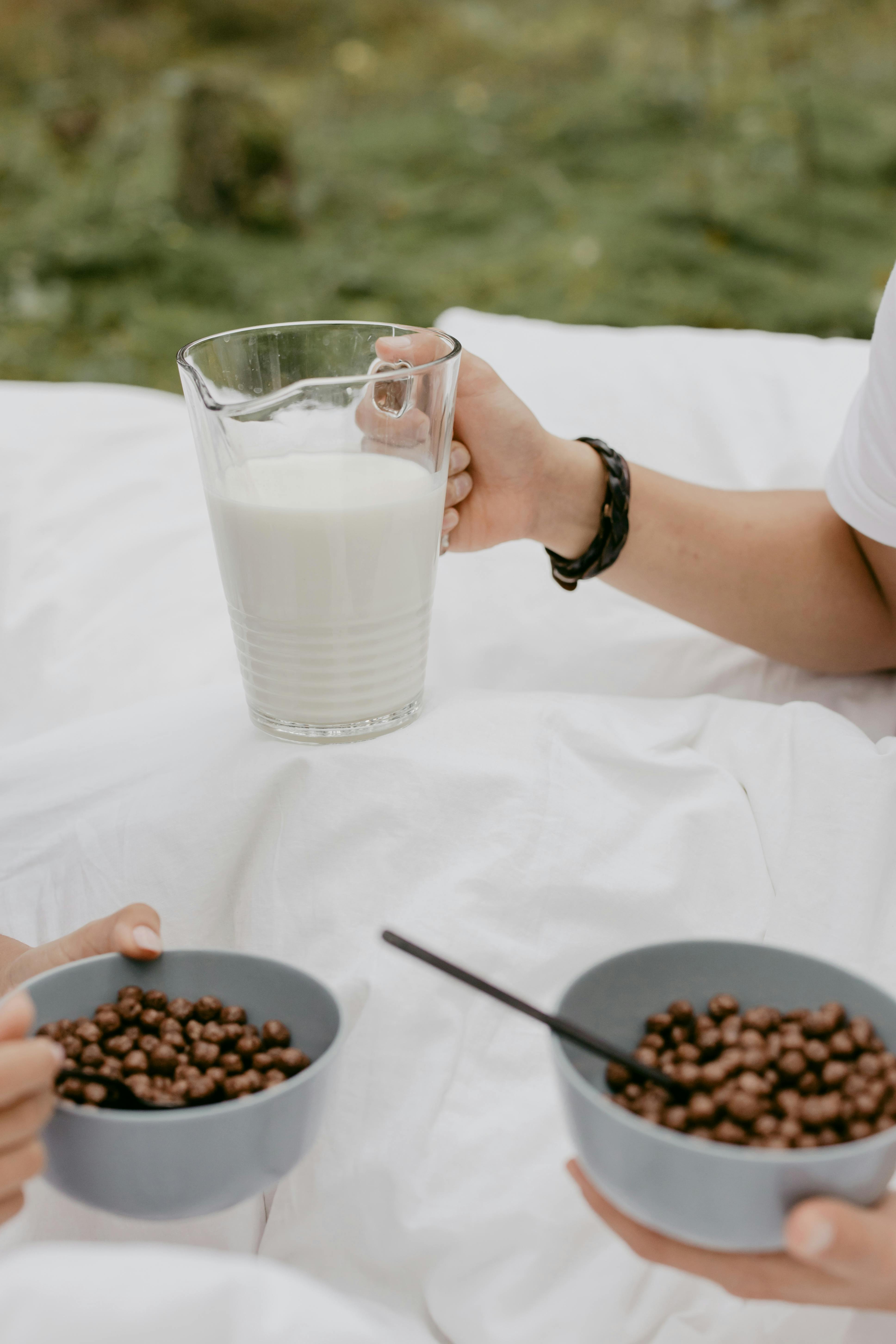 Person Holding a Glass of Pitcher with White Liquid · Free Stock Photo