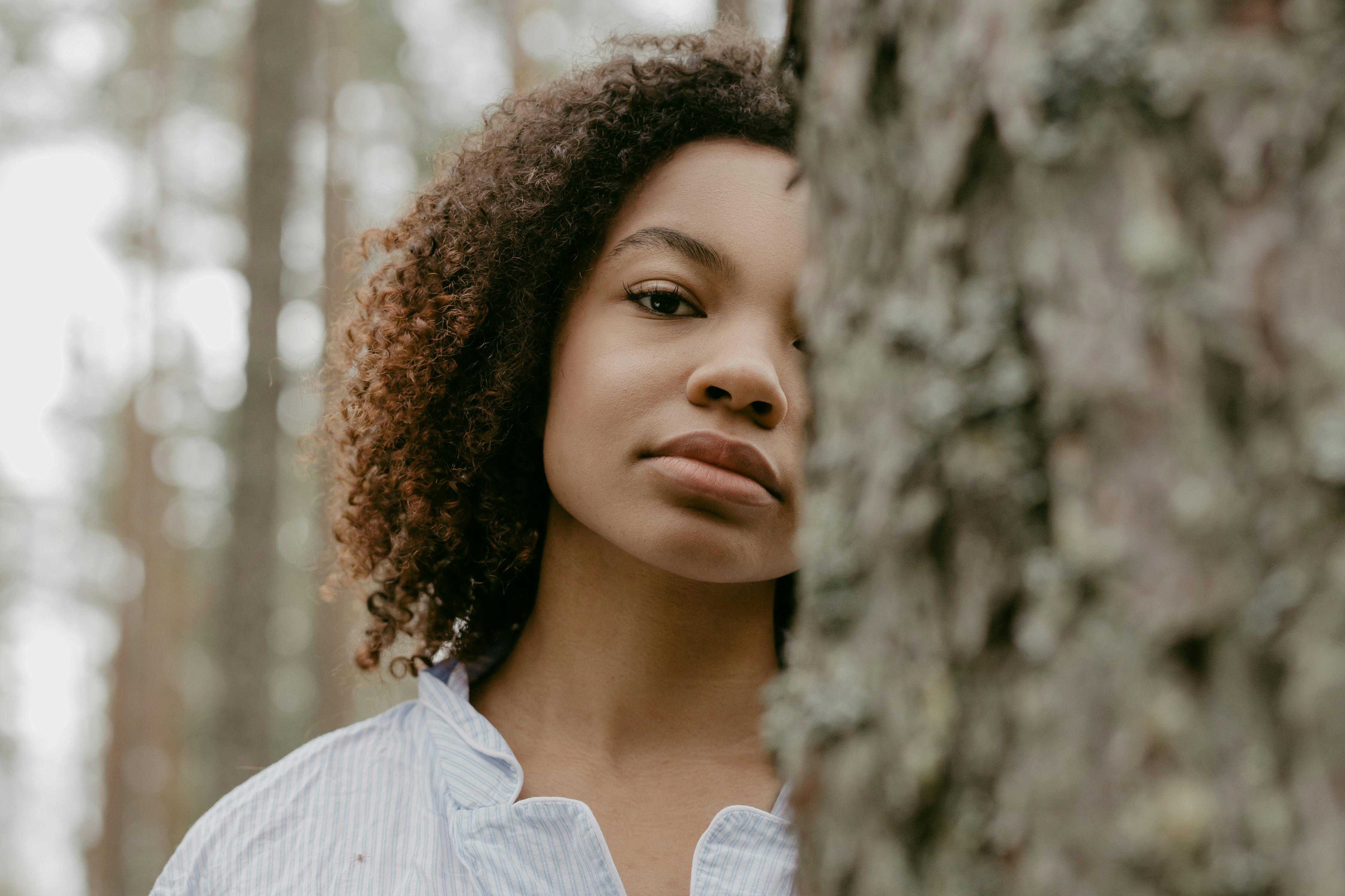 Woman Standing Behind a Tree Trunk · Free Stock Photo