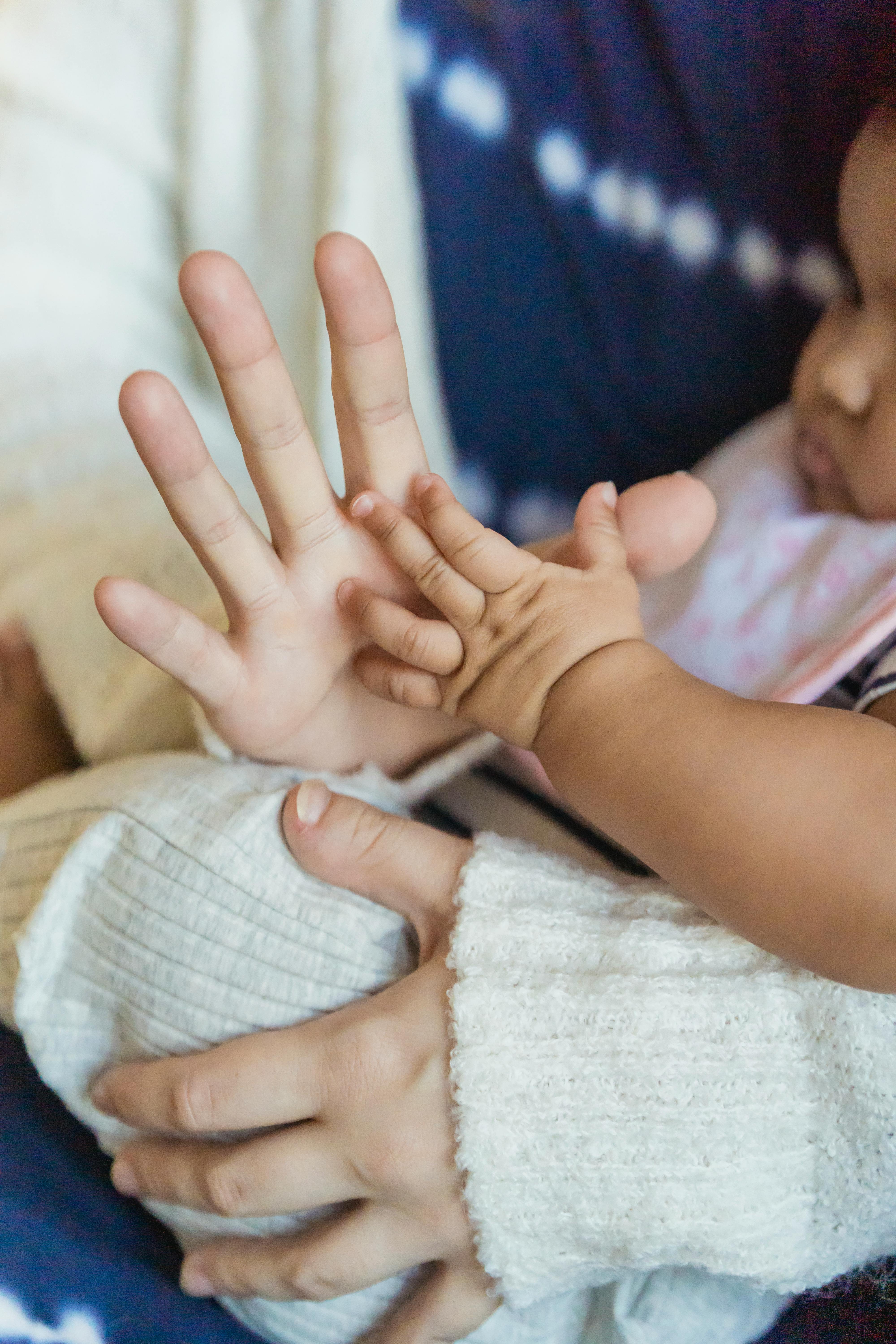 Person Touching a Baby's Hand · Free Stock Photo
