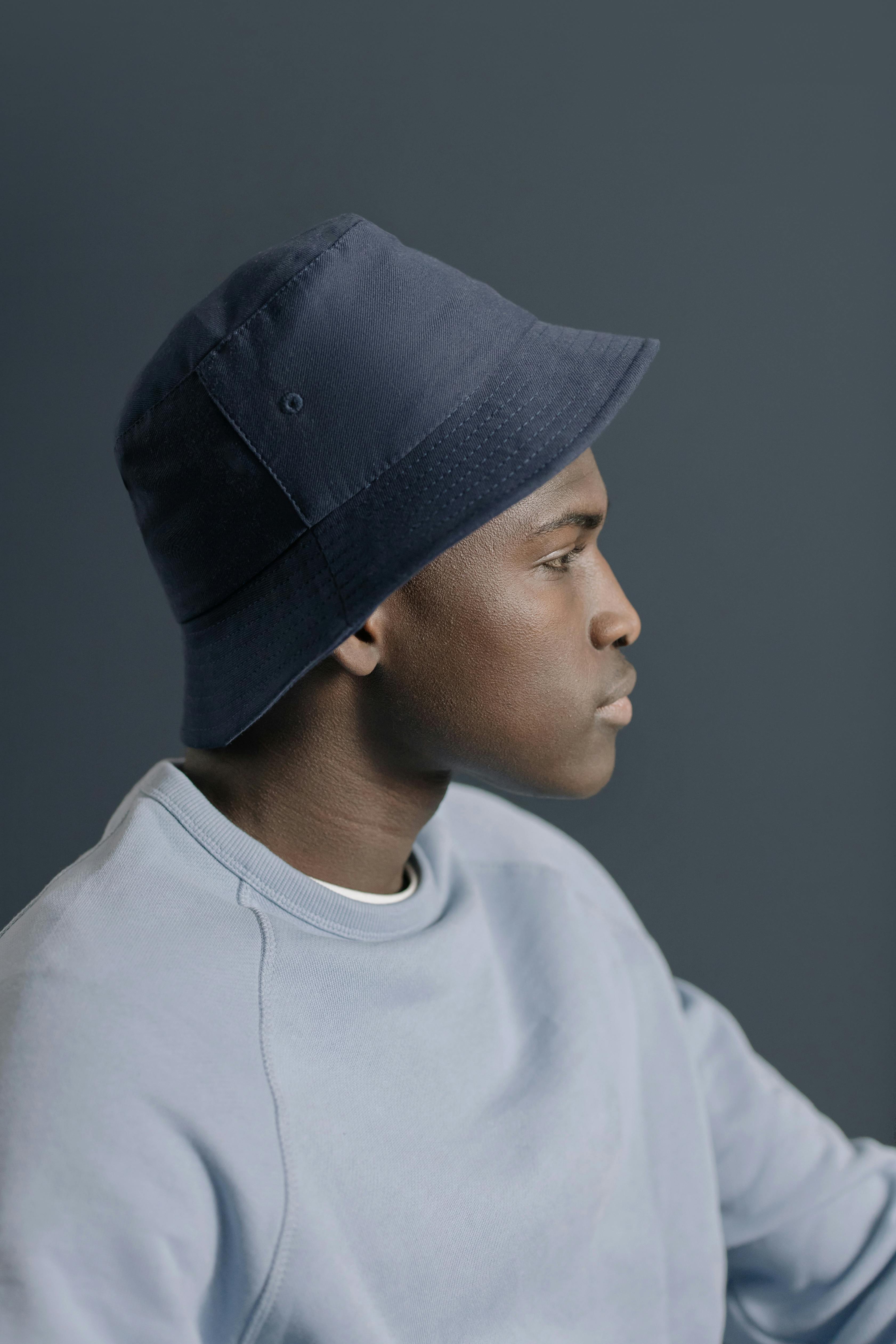 Man in Long Sleeve Shirt and Bucket Hat Covering His Face With a Book ...