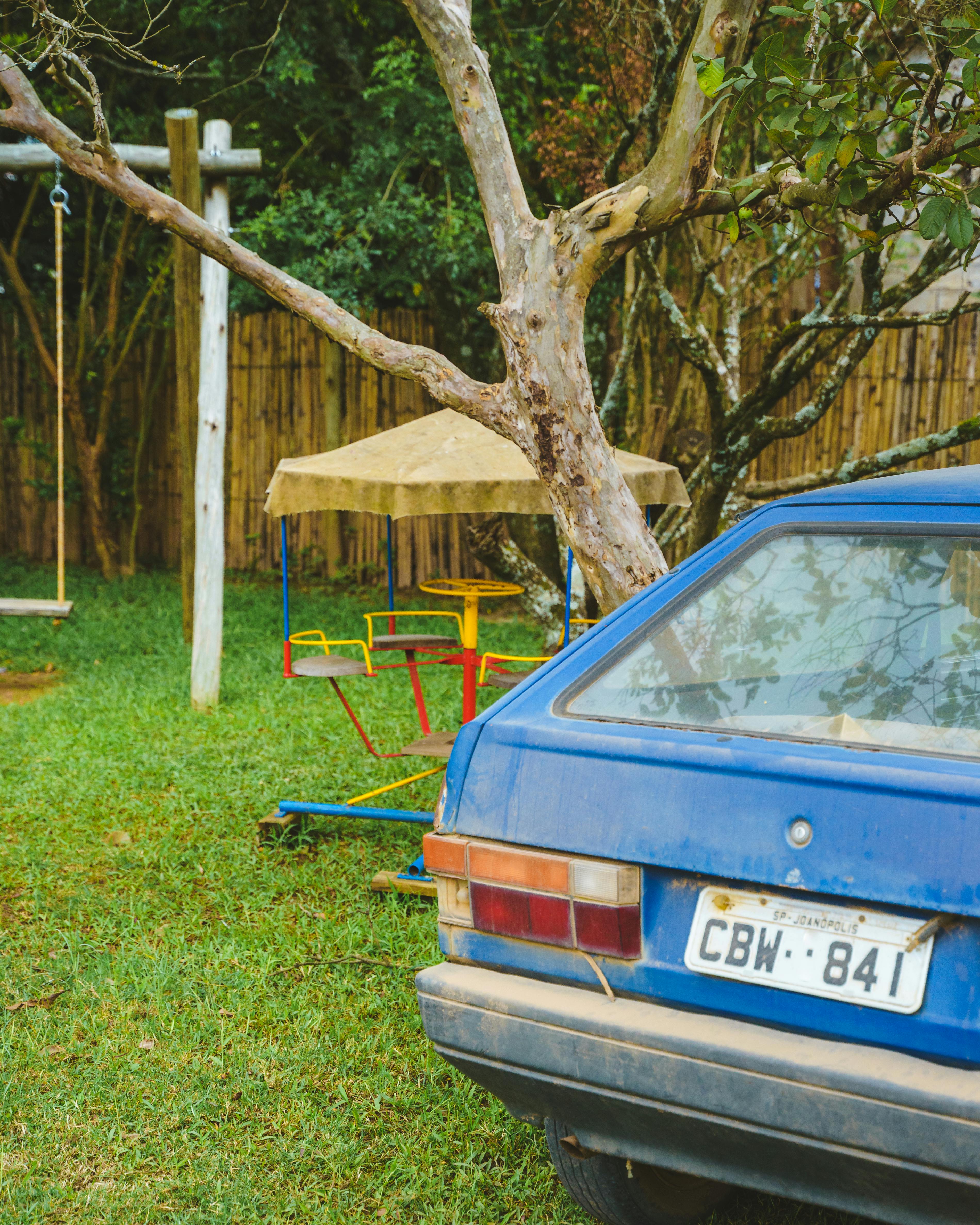 Photo of an Old Car Near a Tree · Free Stock Photo