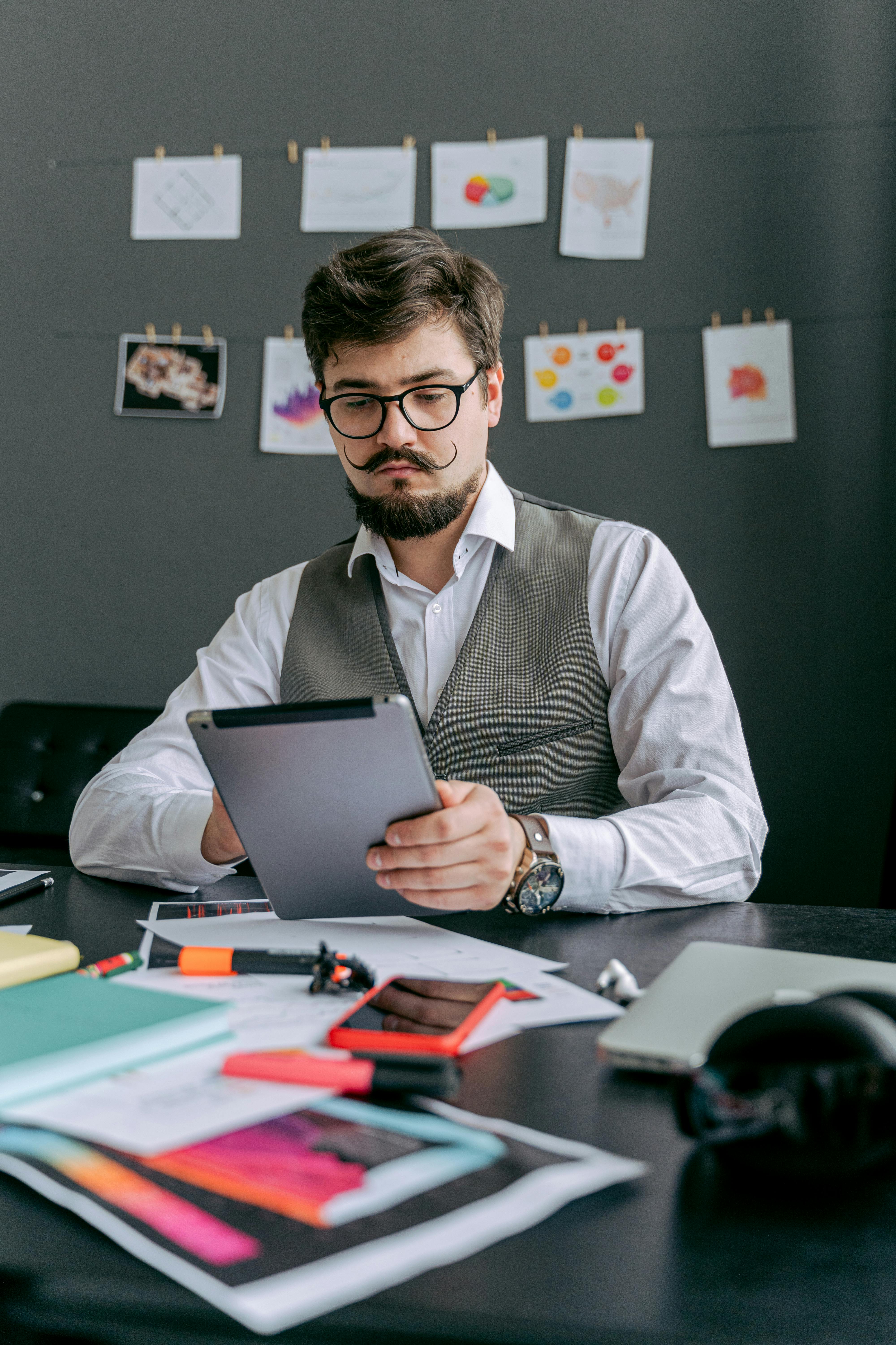Elegantly Dressed Man in an Office Using a Tablet · Free Stock Photo