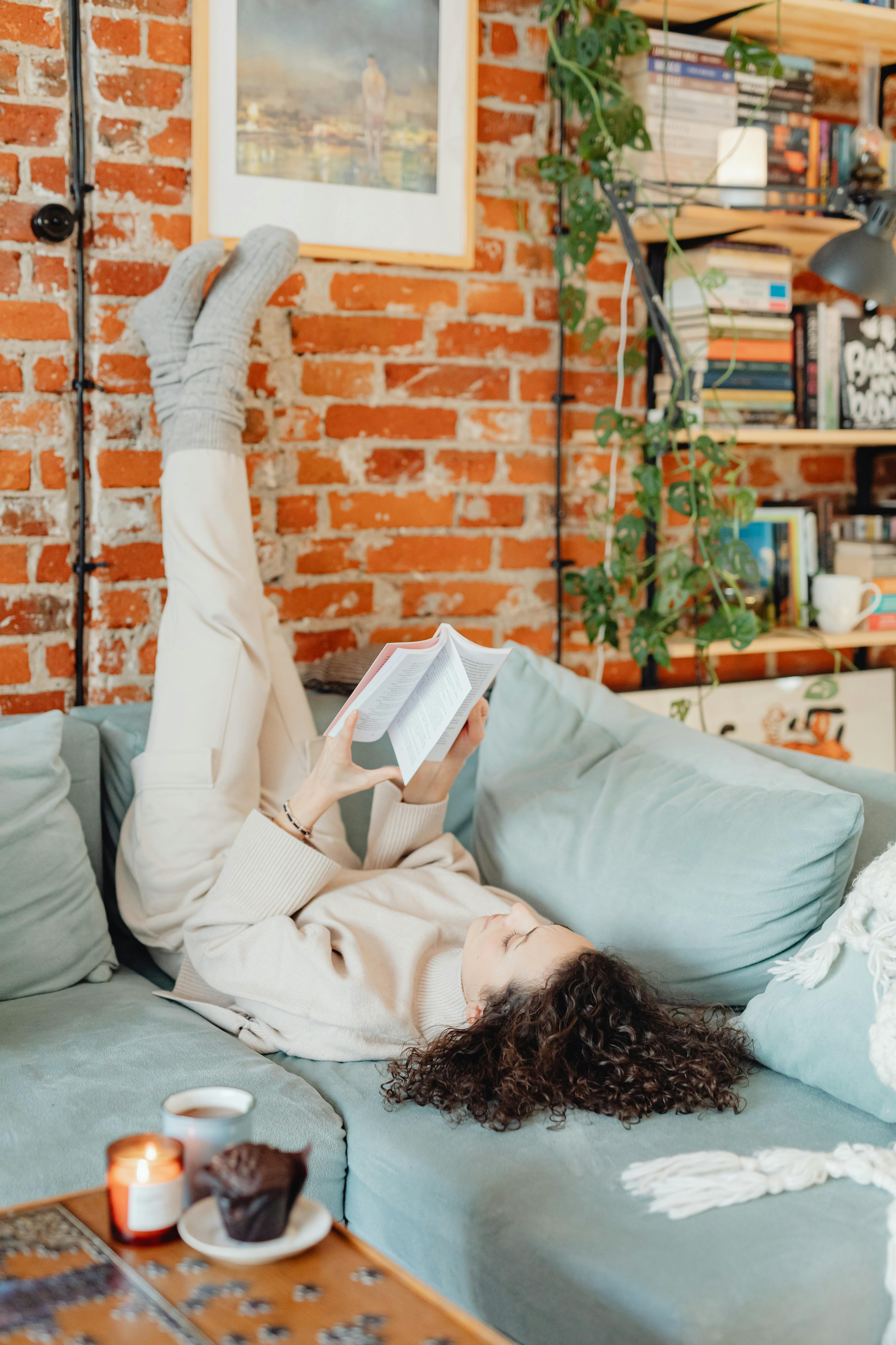 Person Laying on Sofa While Reading Book · Free Stock Photo