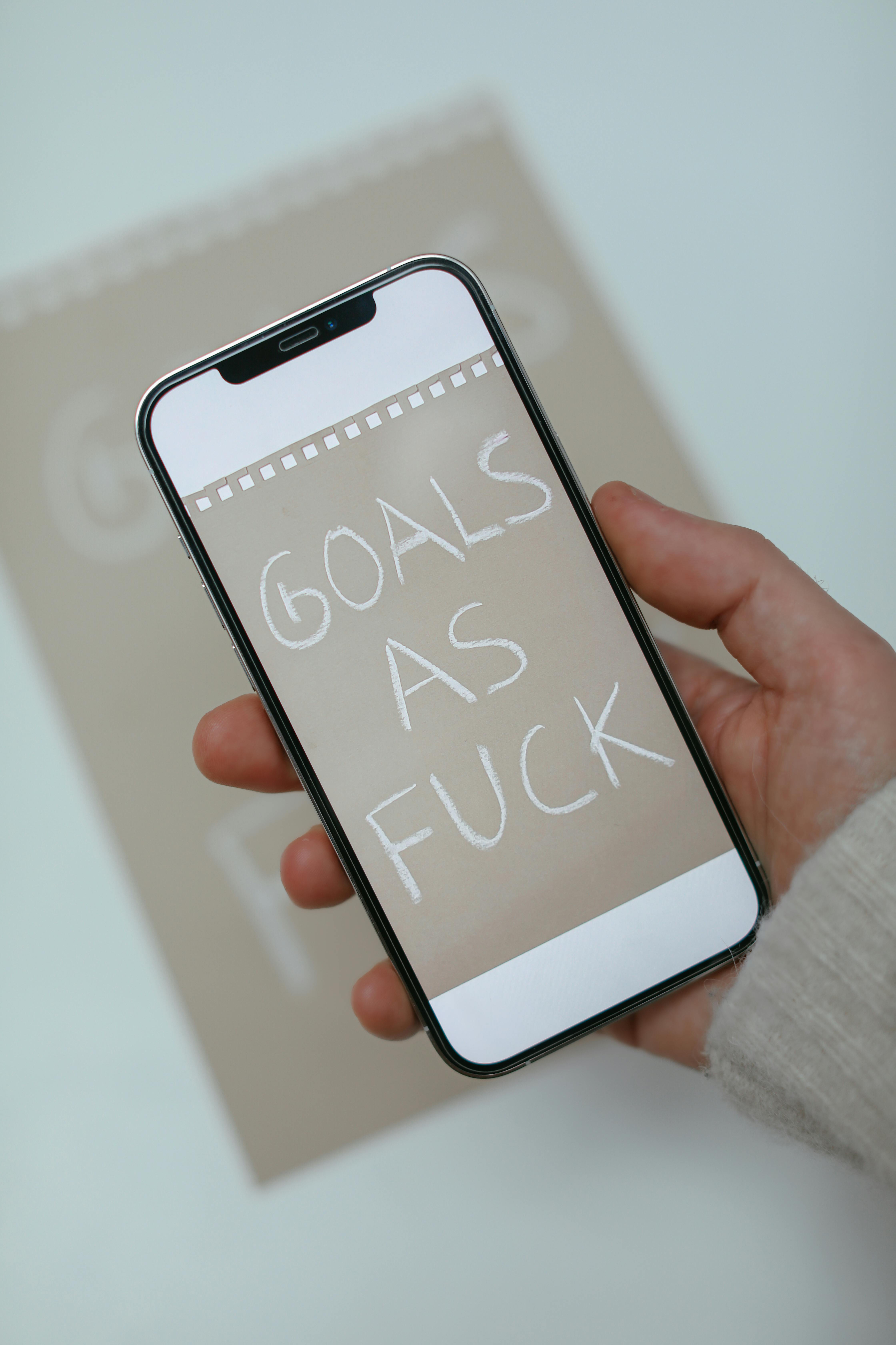Person Holding Smartphone with Text on Screen Display · Free Stock Photo