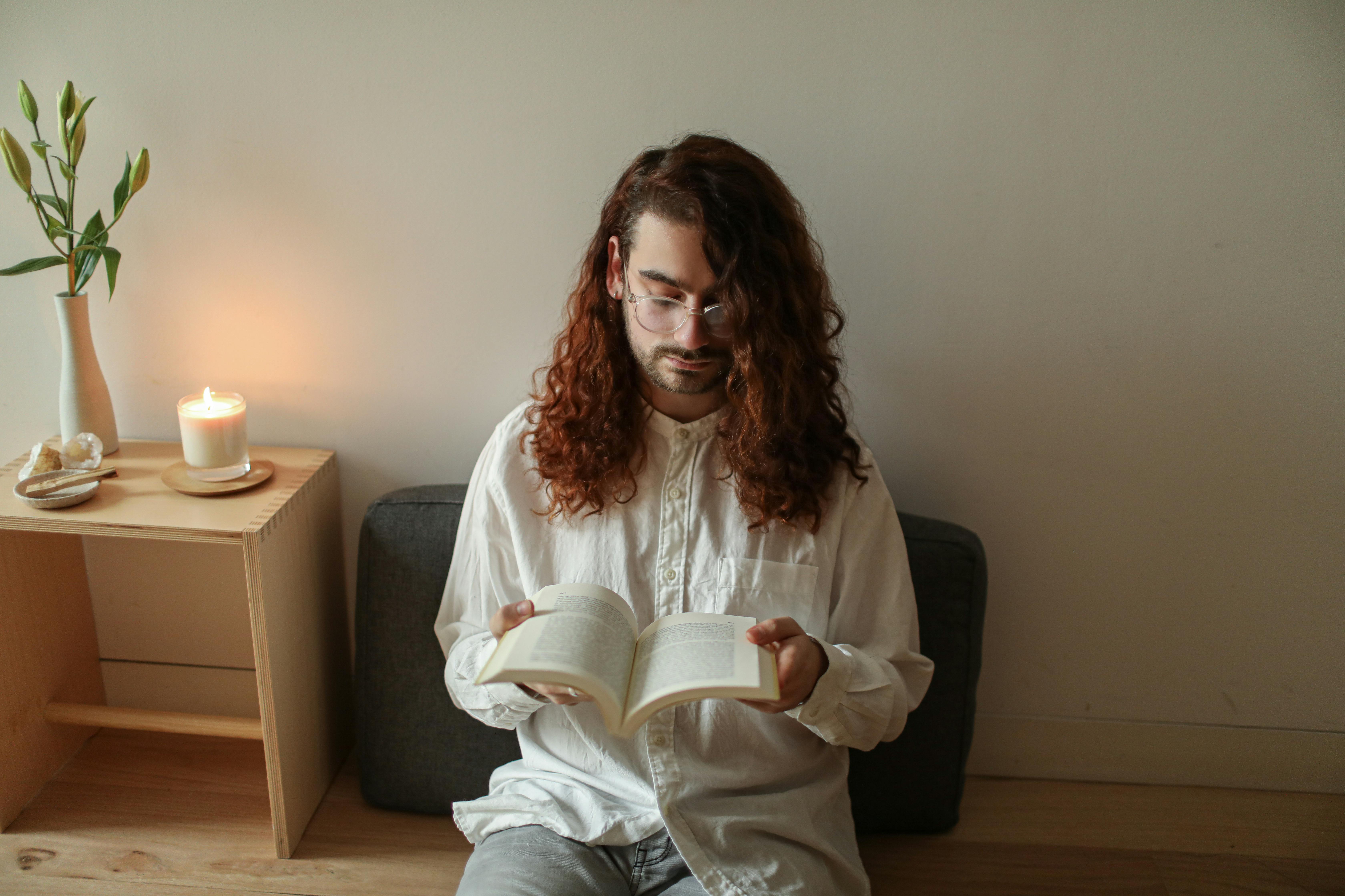 A Man in White Long Sleeves Reading a Book · Free Stock Photo