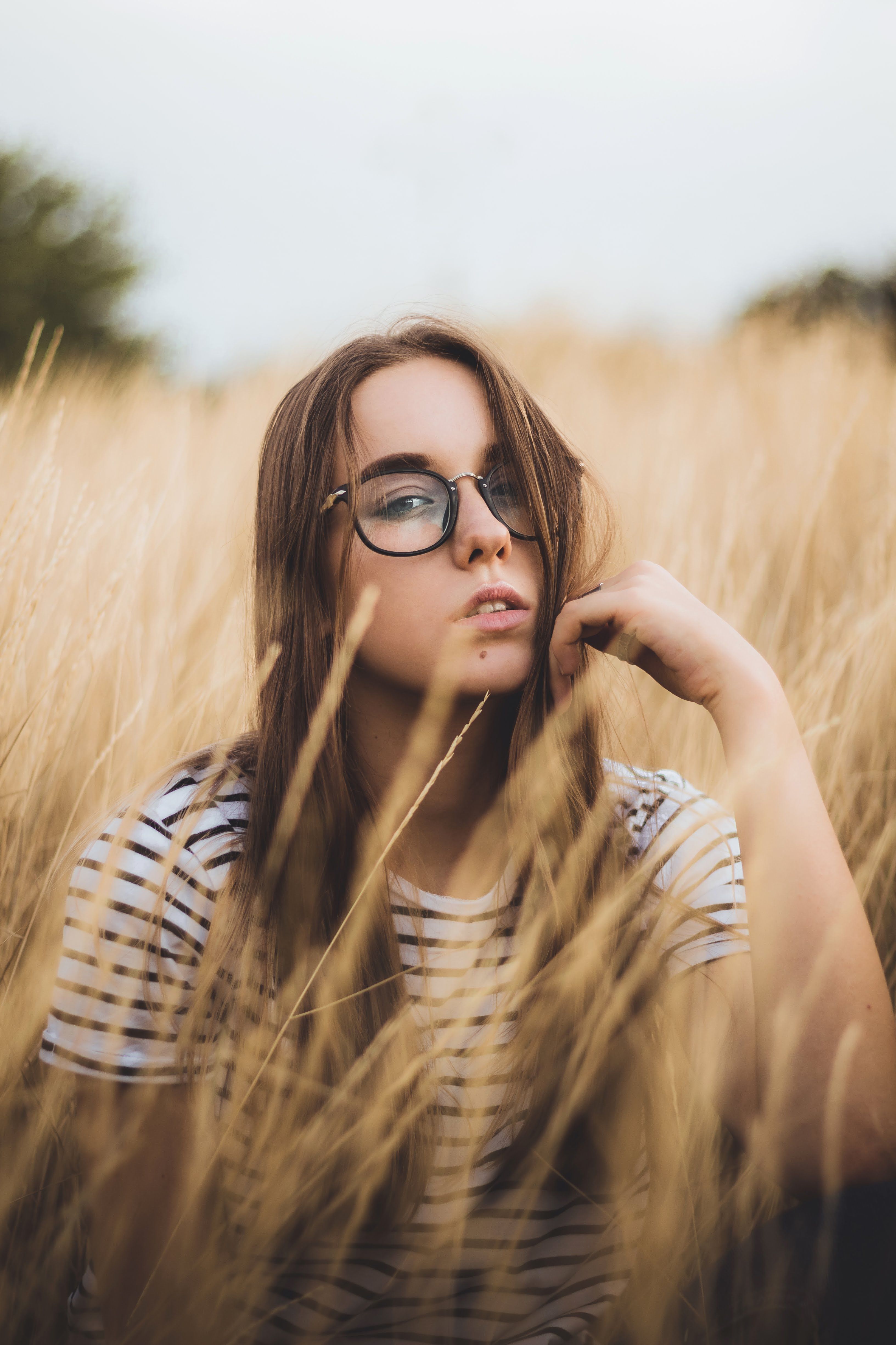 Peaceful young lady recreating near wooden bench in countryside · Free ...