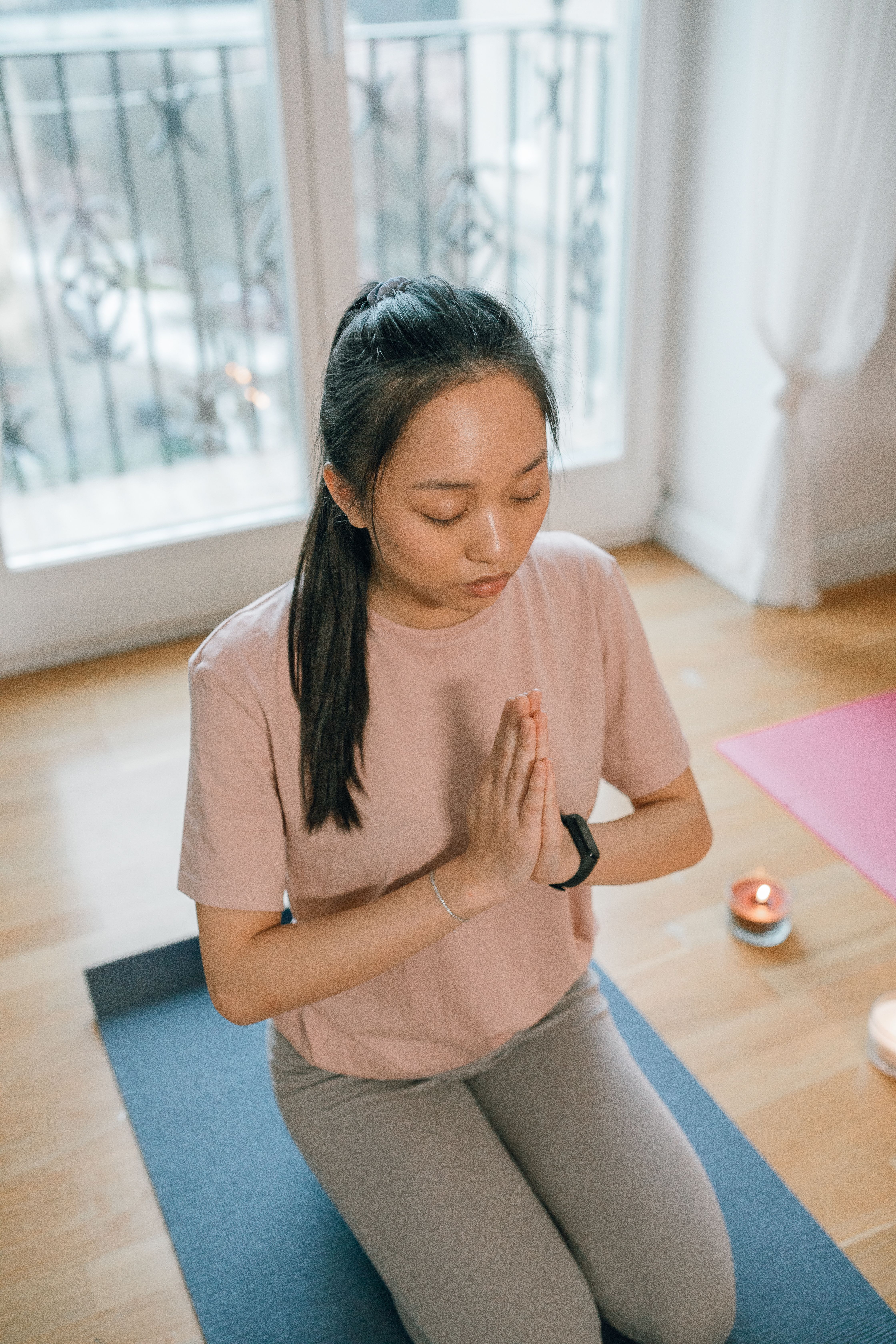 A Woman in Beige Shirt Meditating while Kneeling on Yoga Mat · Free ...