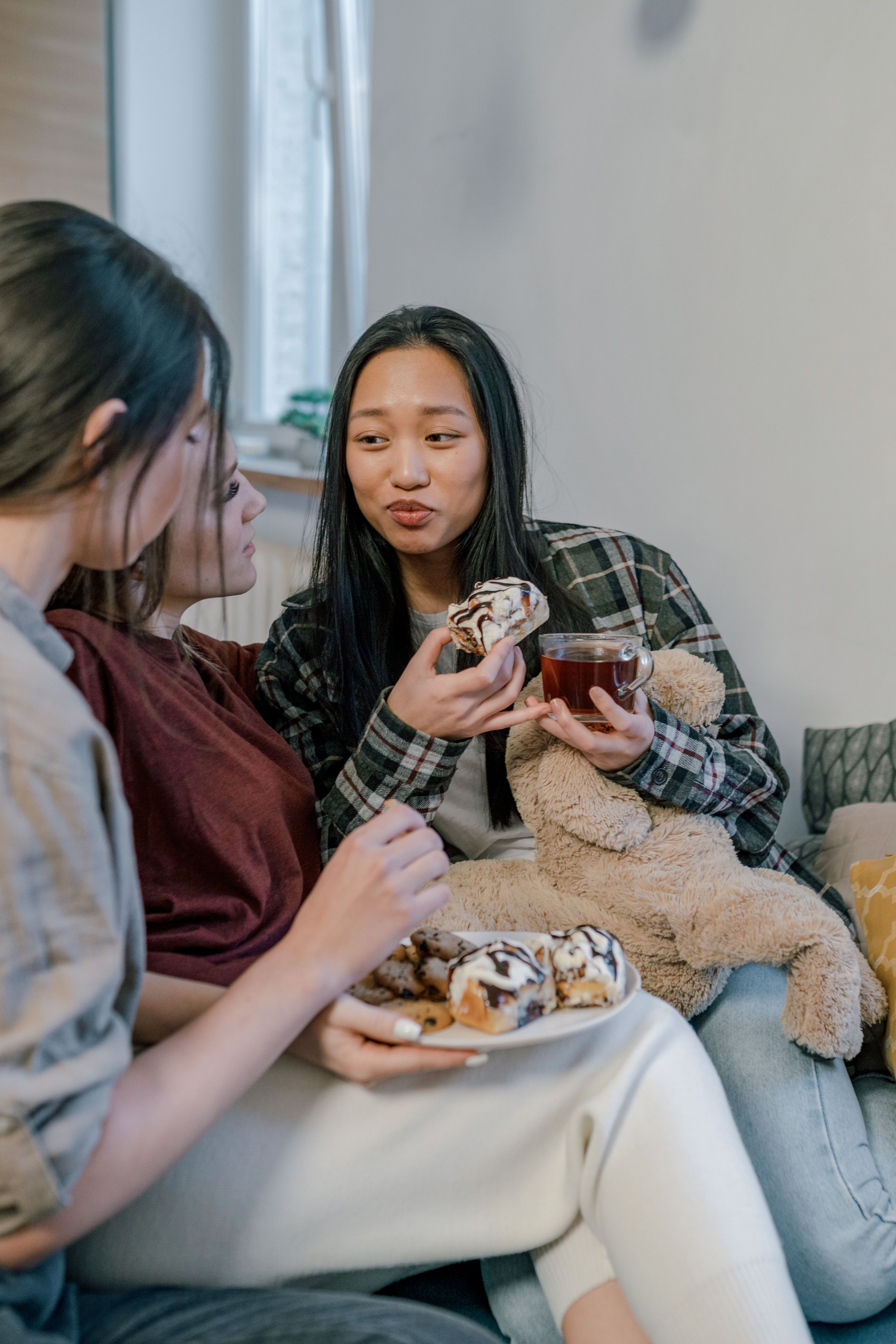 Girls Sitting on Couch Holding Desserts · Free Stock Photo