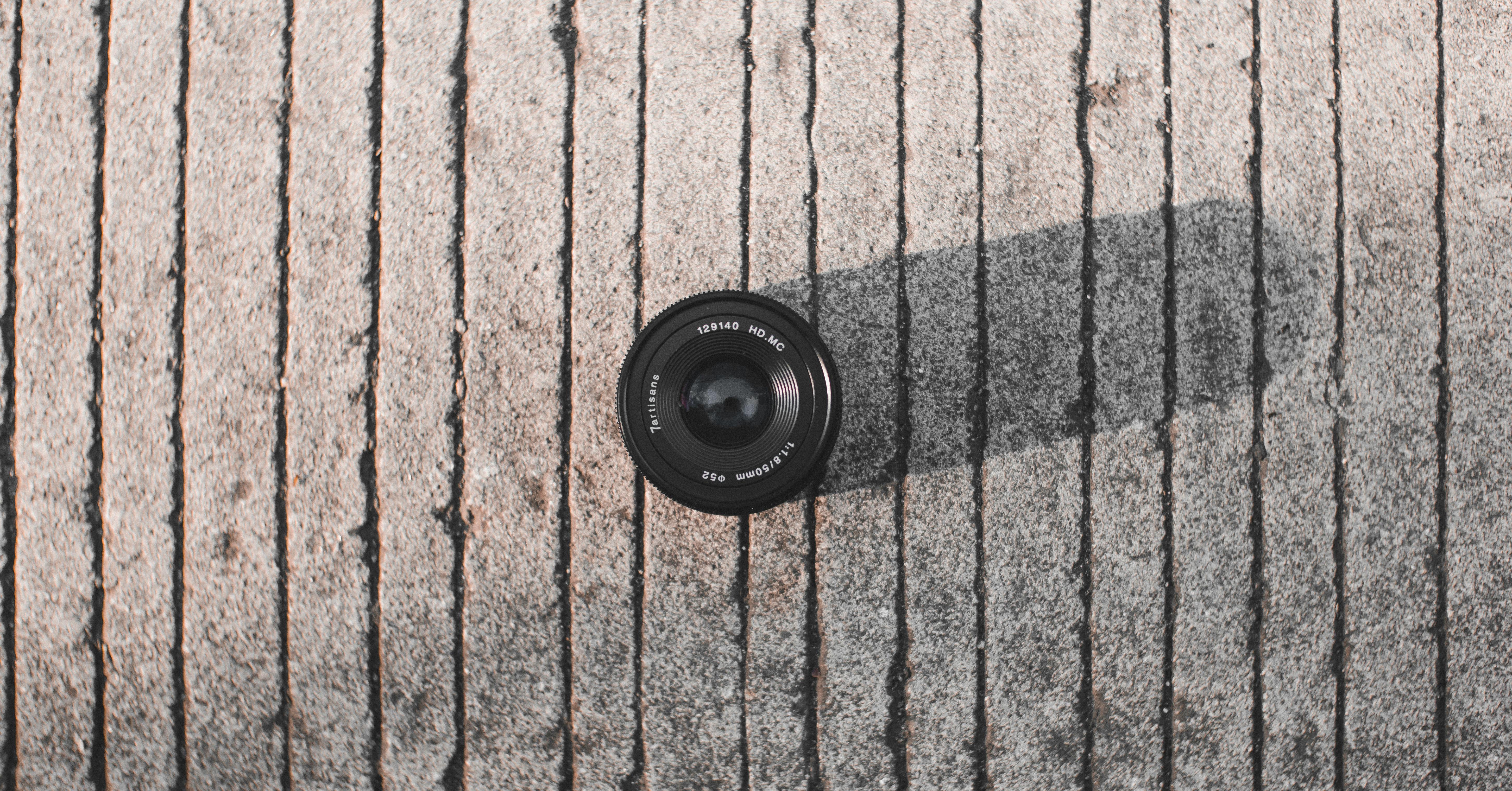 Digital photo camera lens on boardwalk with shade · Free Stock Photo