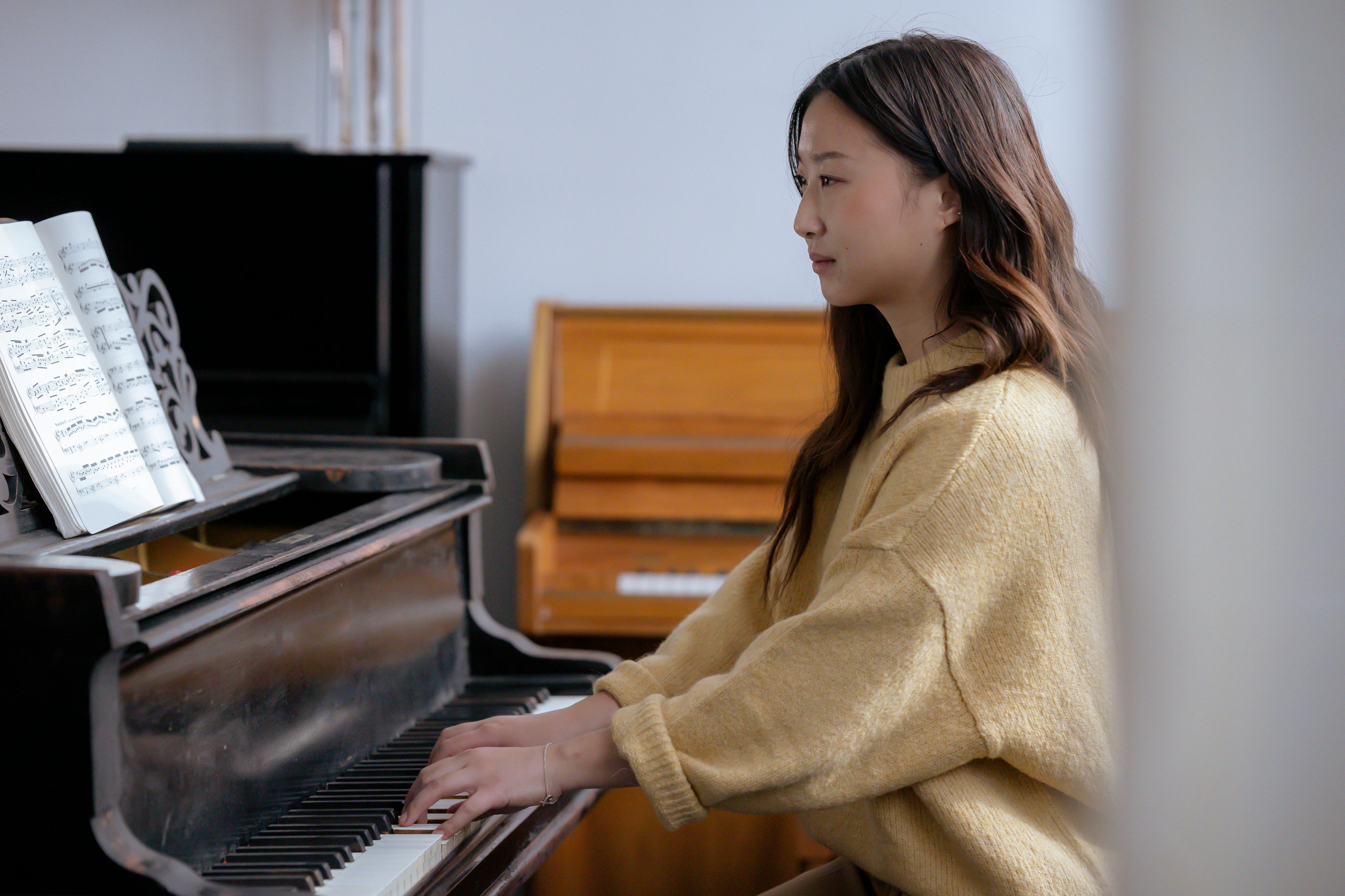 Ethnic female musician playing on piano in room · Free Stock Photo
