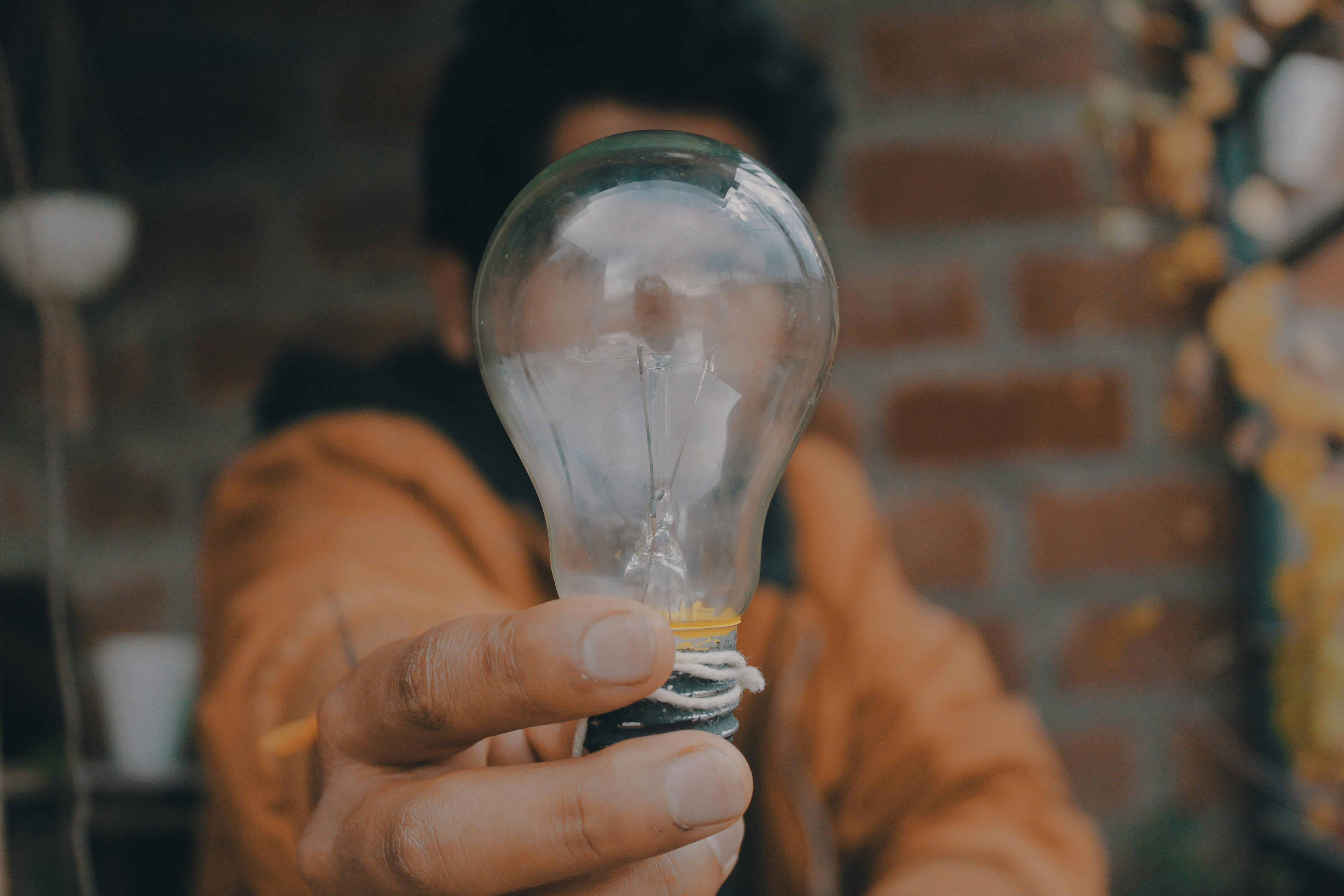 A Man Holding a Light Bulb · Free Stock Photo