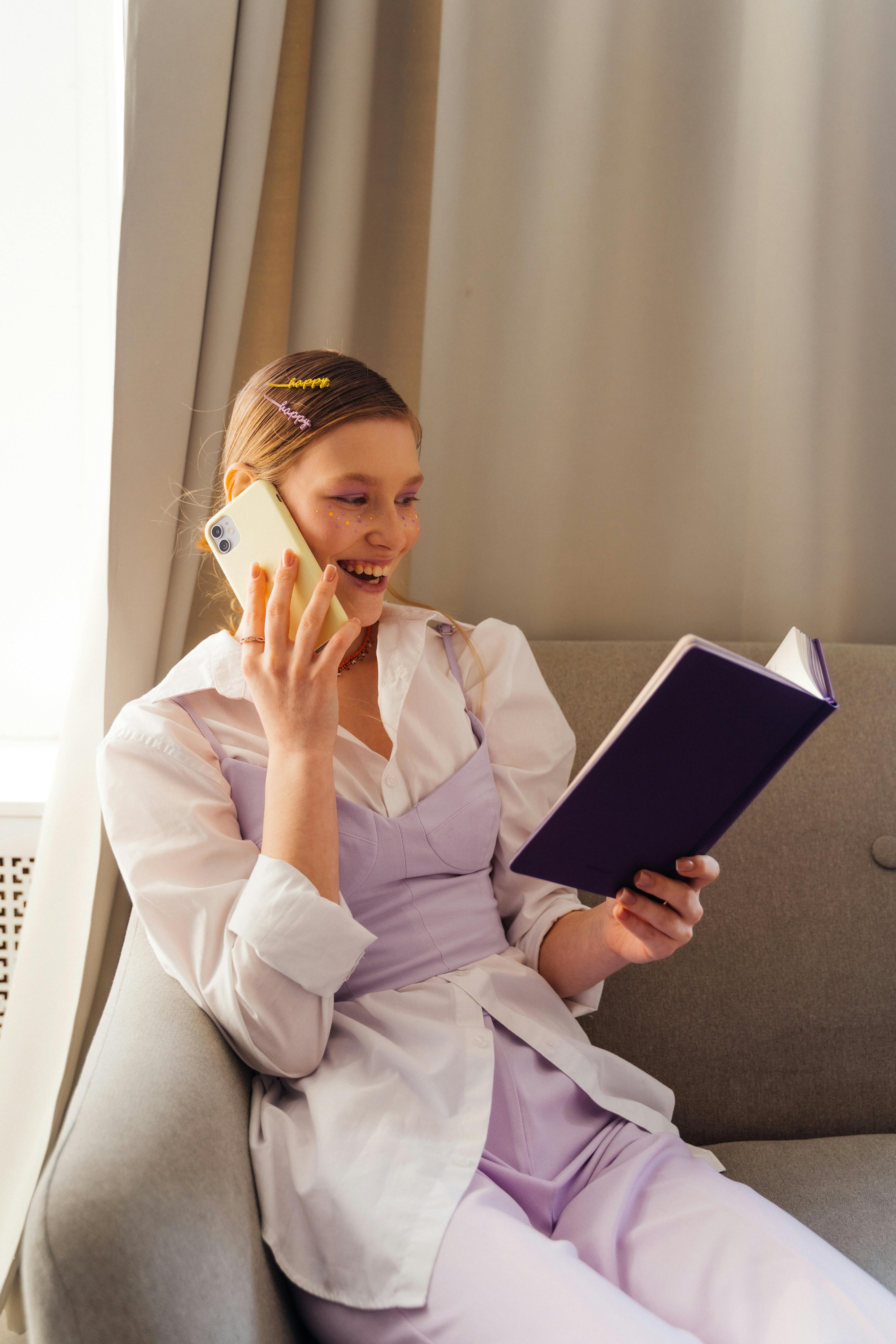 A Woman Reading a Book while Having a Phone Call · Free Stock Photo
