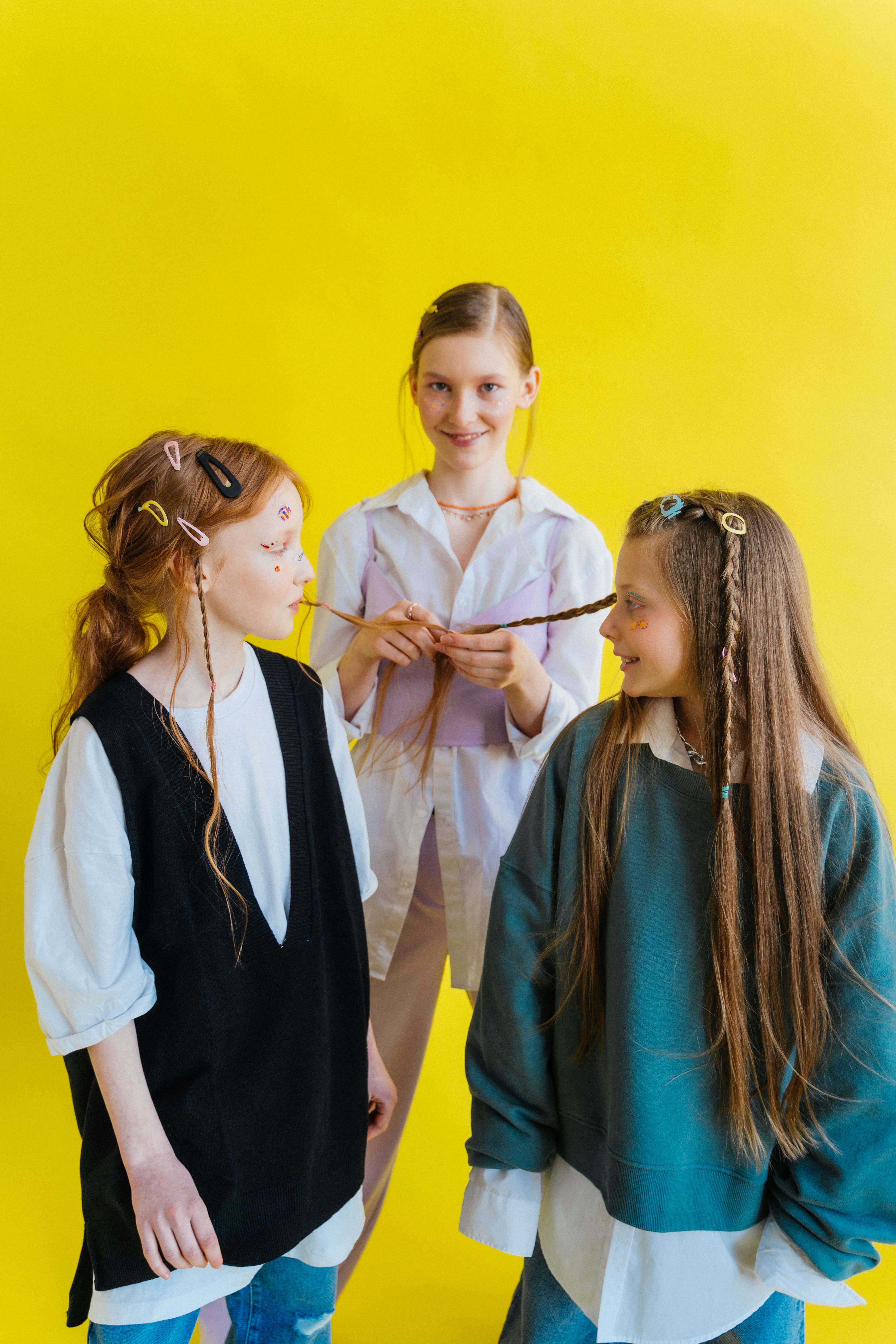 Three Girls Standing on Yellow Background · Free Stock Photo