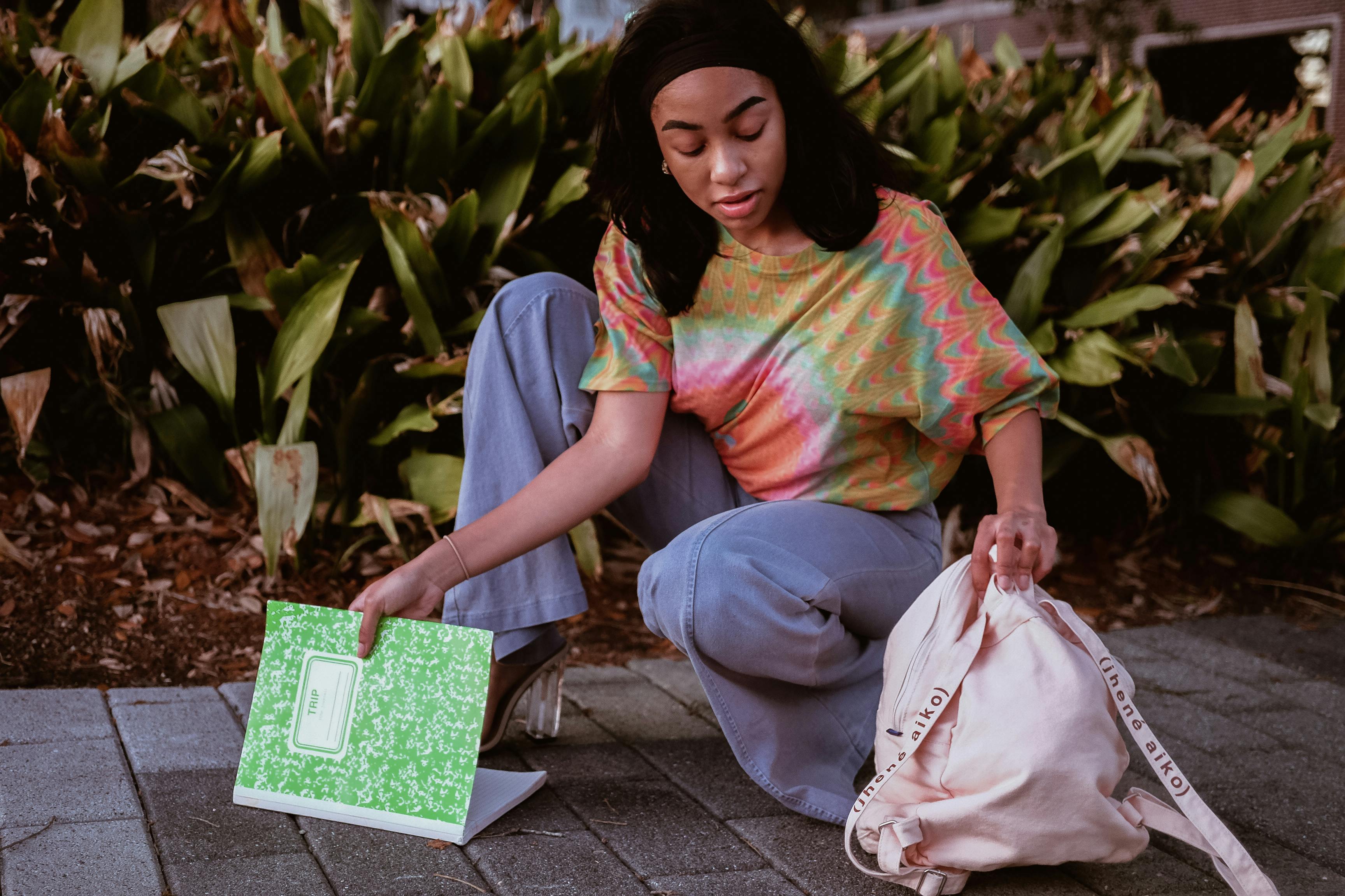 Woman Picking Up a Notebook from the Floor · Free Stock Photo